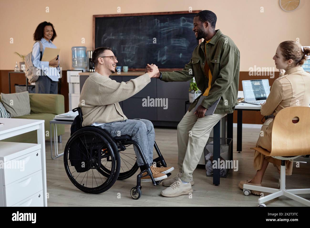Happy businessman with disability shaking hands with colleague in ...