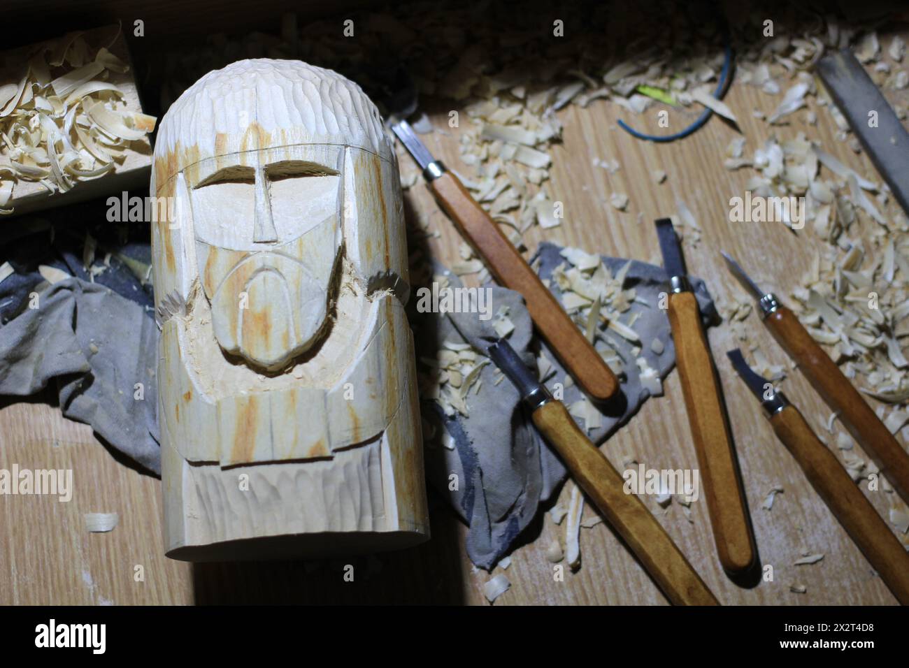 The process of wood carving. Carved old man or pagan deity Stock Photo ...
