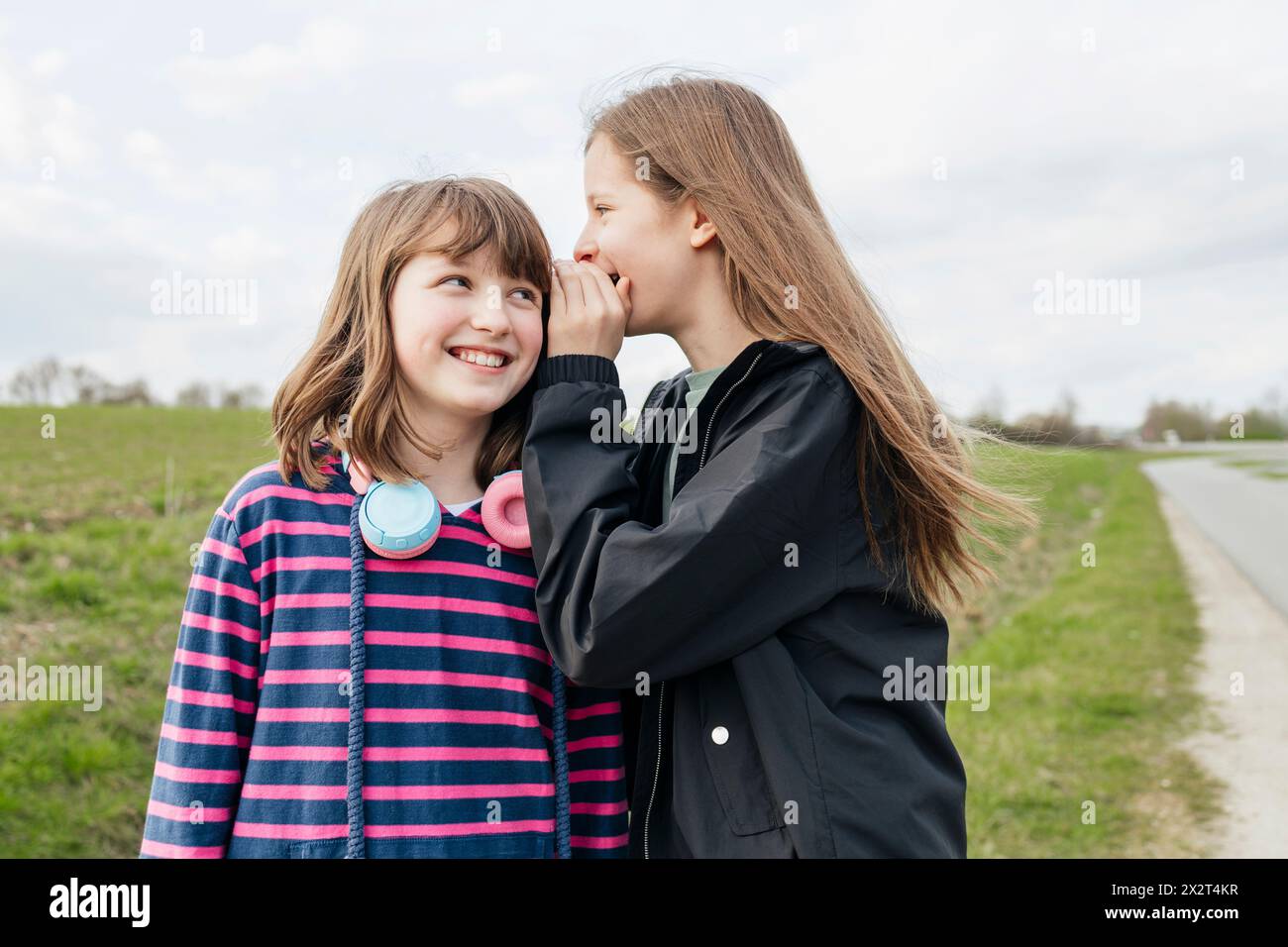 Child whispering in her ear hi-res stock photography and images - Alamy