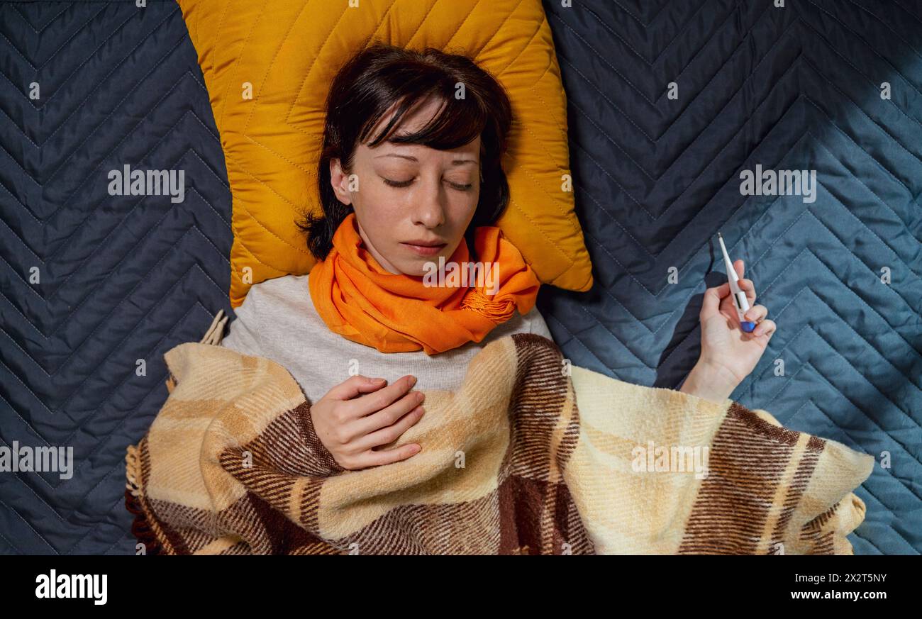 Sick woman with thermometer sleeping on bed at home Stock Photo - Alamy