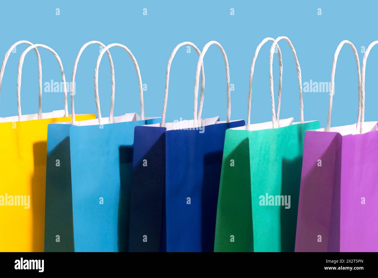 Colorful paper bags against blue background Stock Photo - Alamy