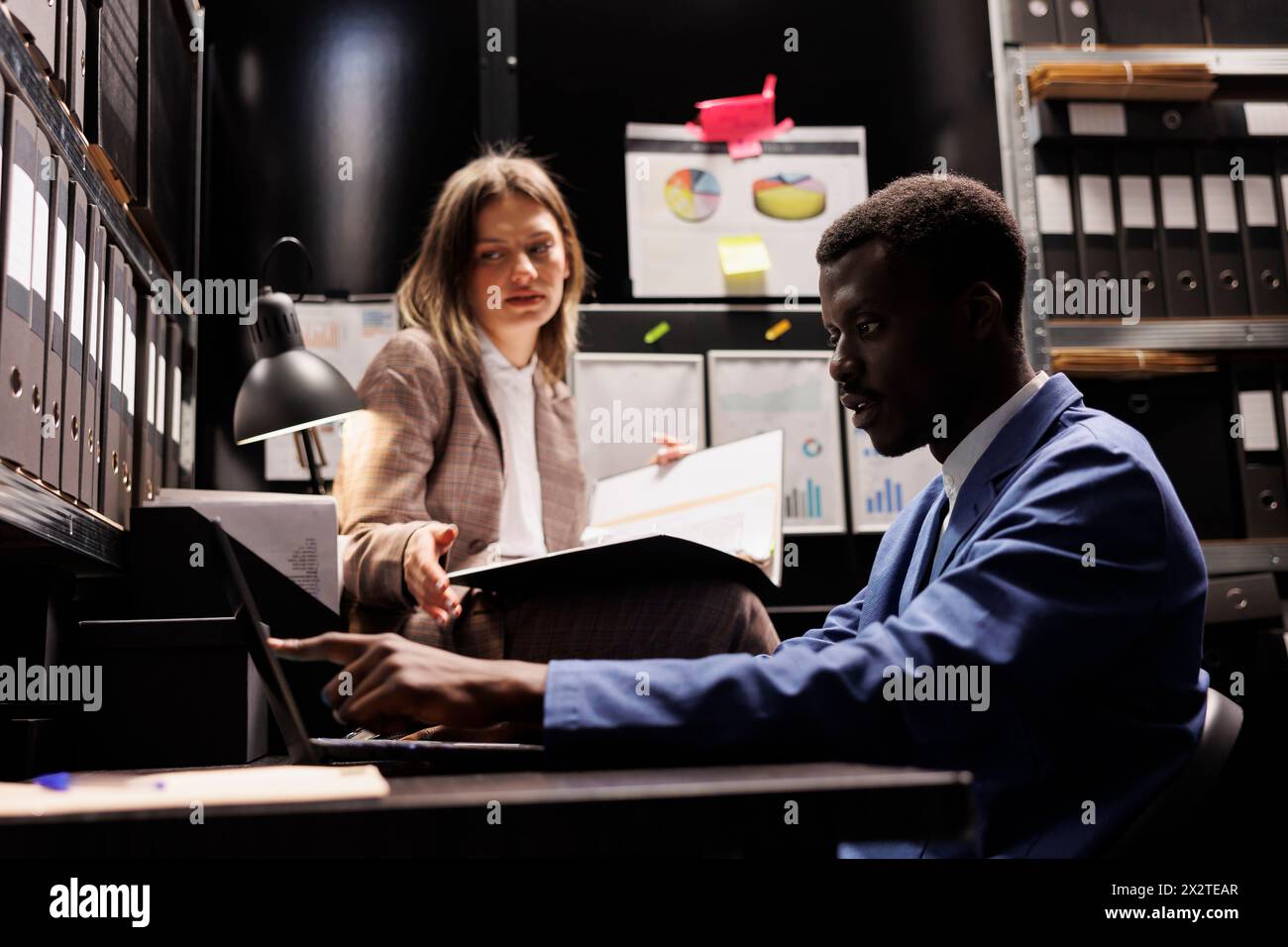 Police officers analyzing criminology report, working overtime at ...