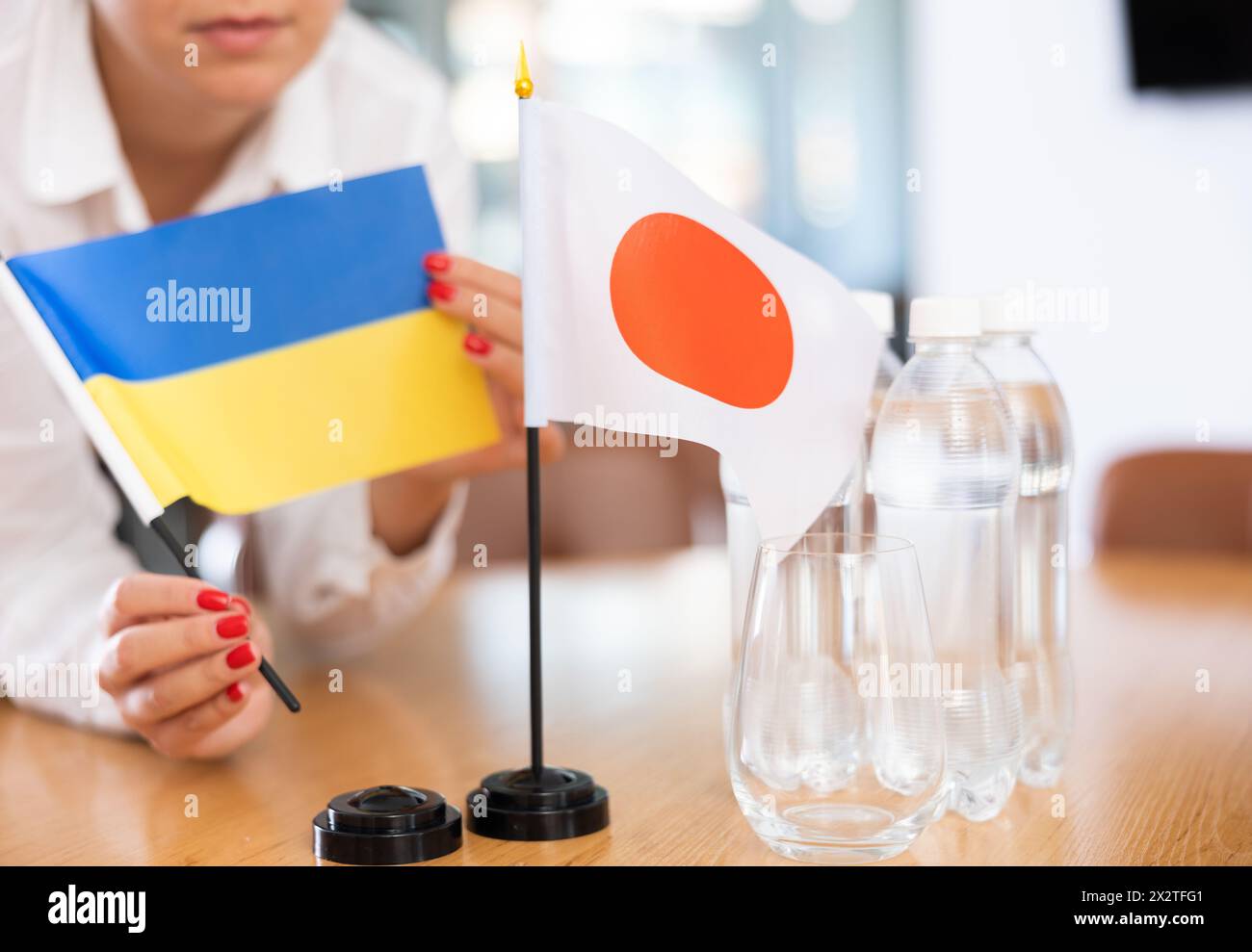 Female hands placing flags of Ukraine and Japan in meeting room Stock ...