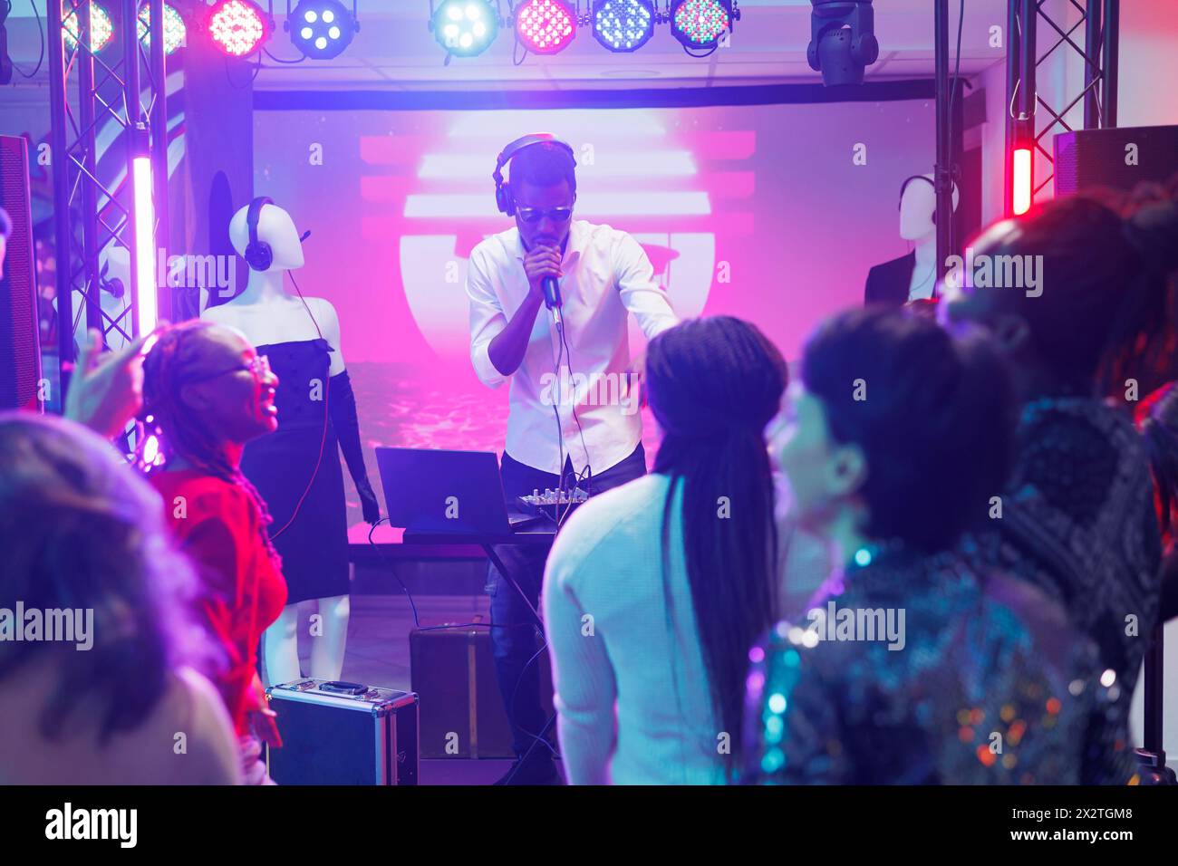 Young man dj mixing music using controller and singing in microphone on ...