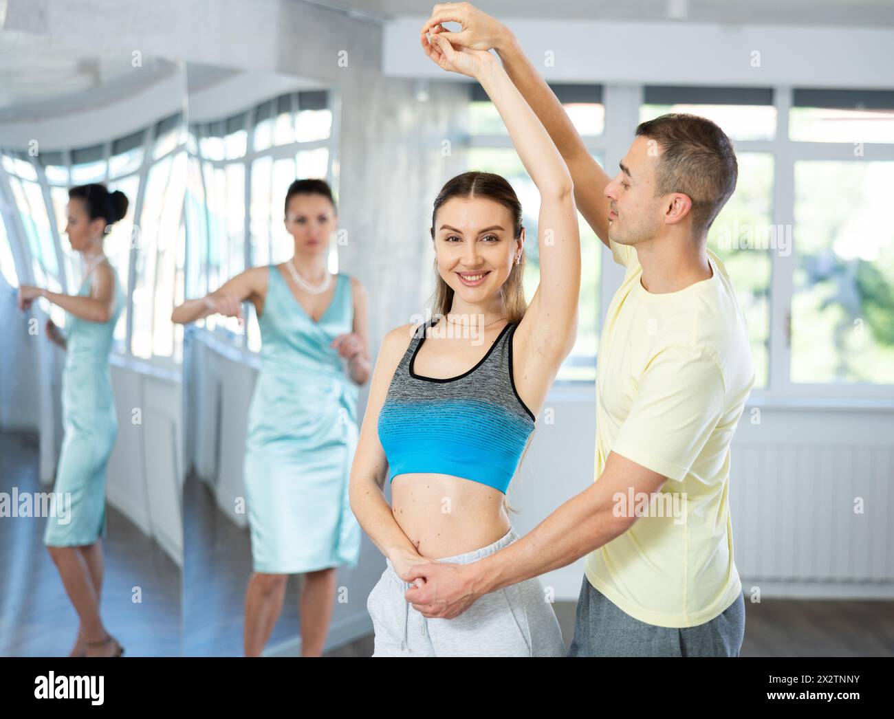 Couple in comfortable sports clothes waltz dancing during individual ...