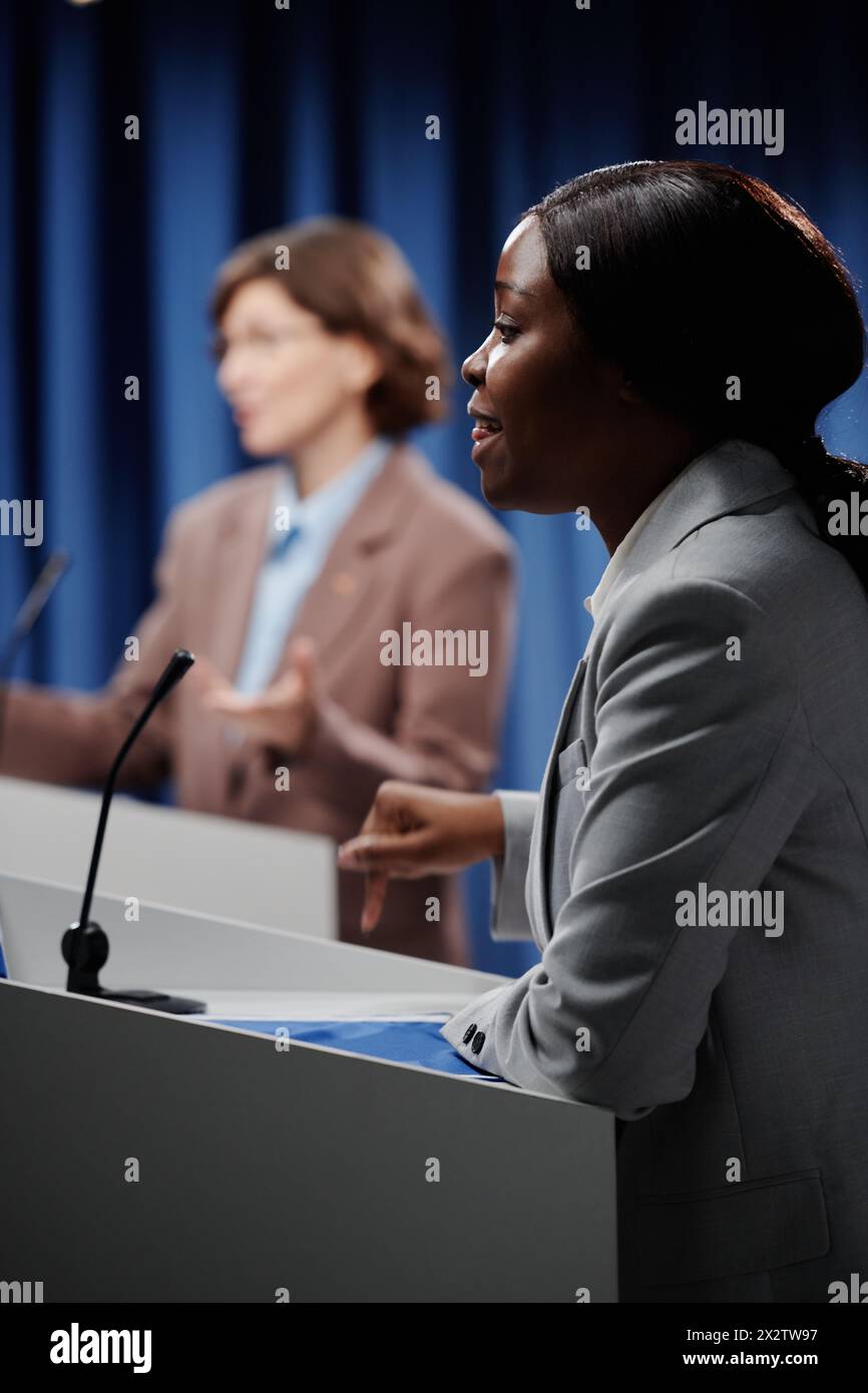 Focus on young confident female politician speaking in microphone while ...