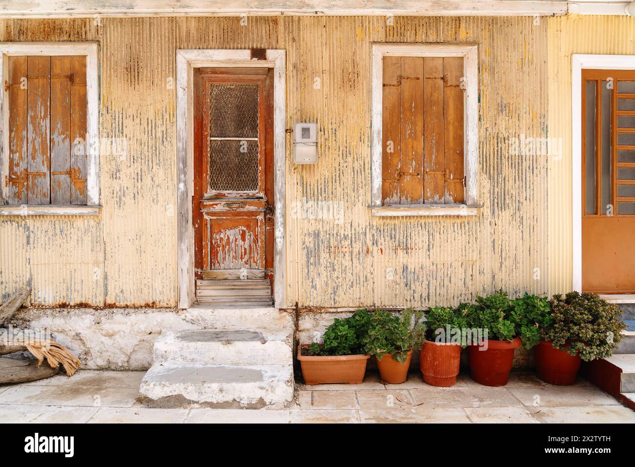 Vintage weathered house facade with potted plants Stock Photo - Alamy