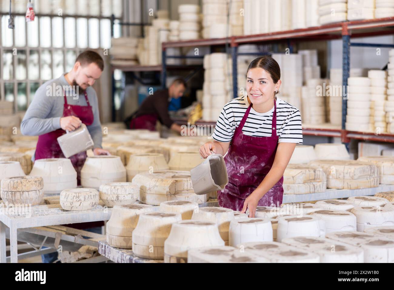 Young woman pouring clay into mold Stock Photo - Alamy