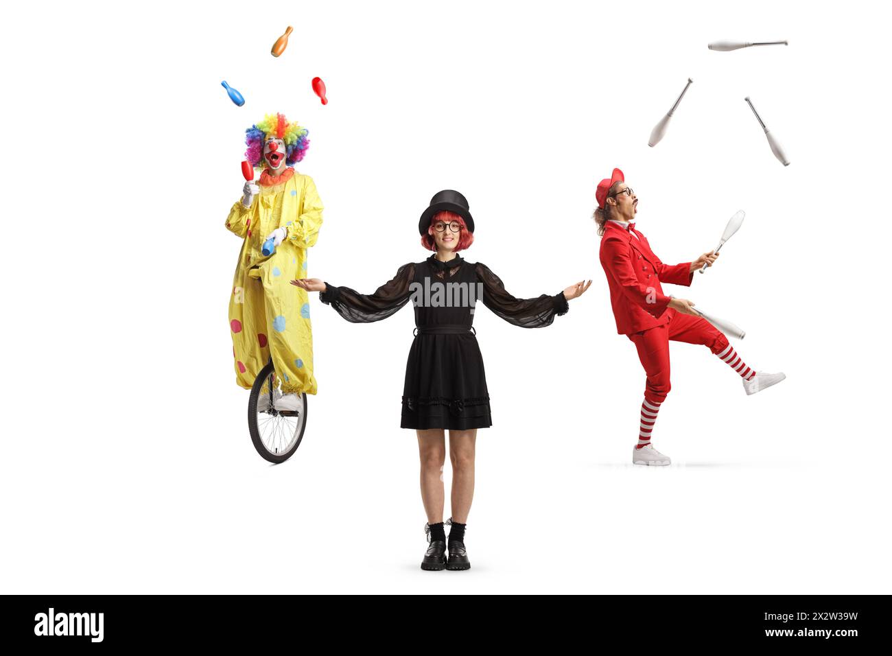 Female magician standing in front of a clown and juggler isolated on ...