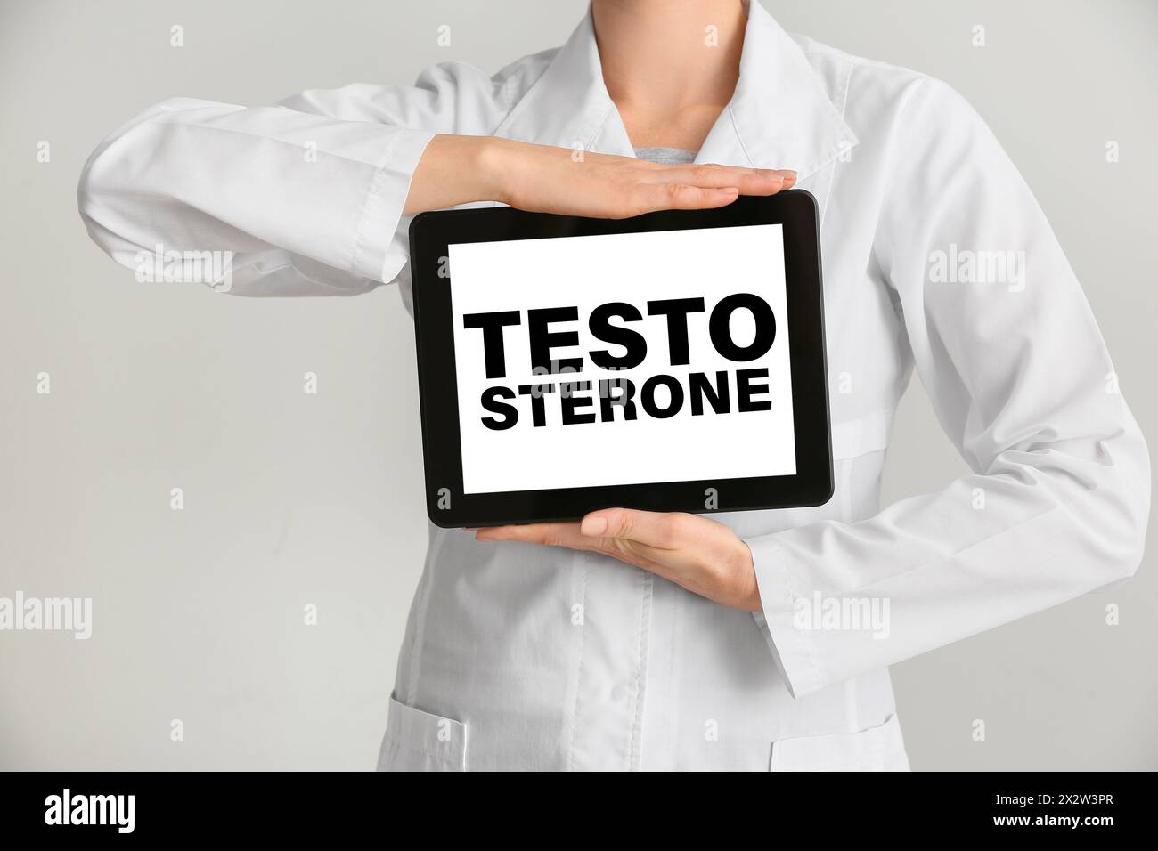 Female doctor holding tablet computer with word TESTOSTERONE on screen ...