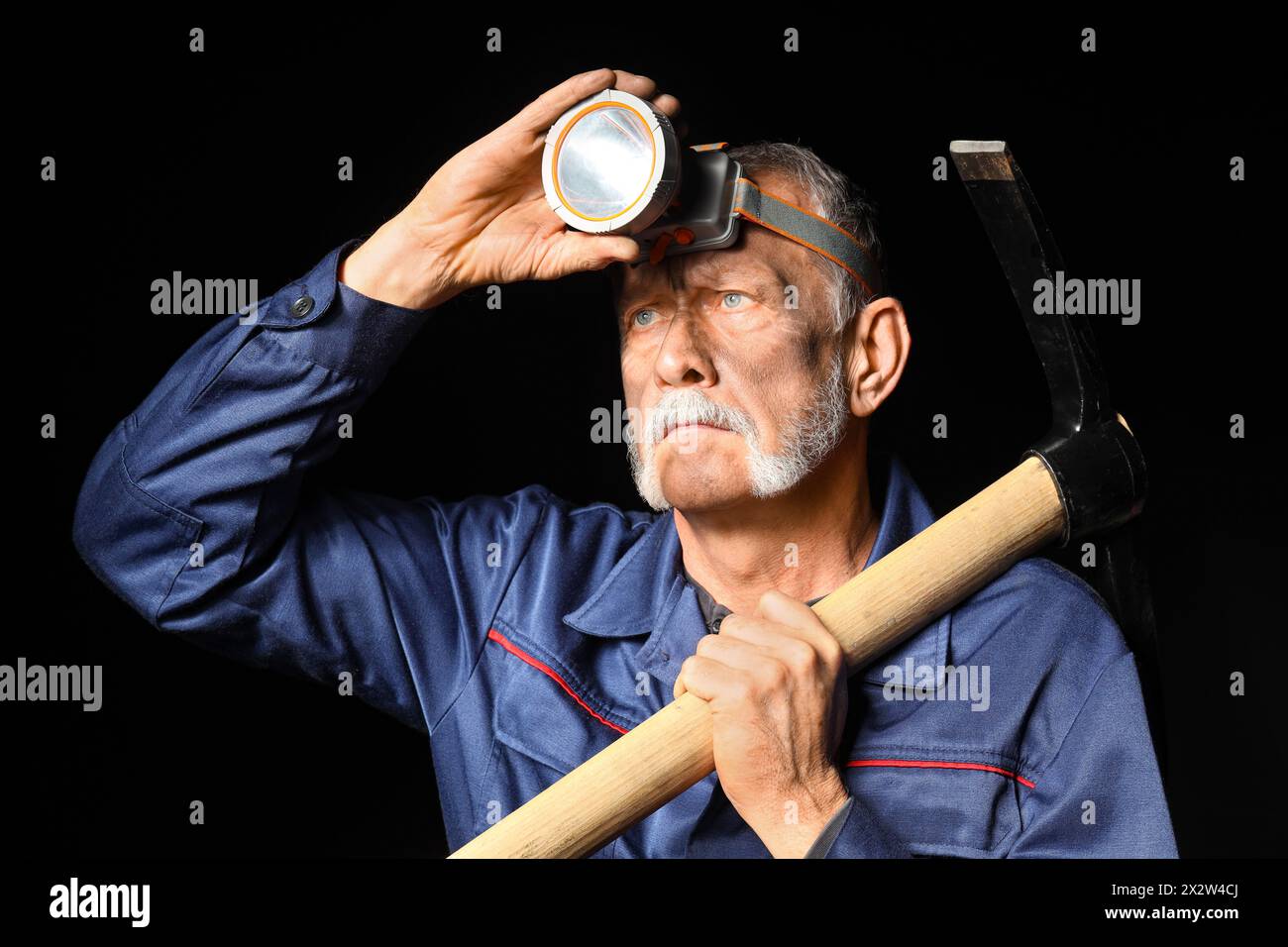 Mature miner man with headlamp and pick axe on black background ...