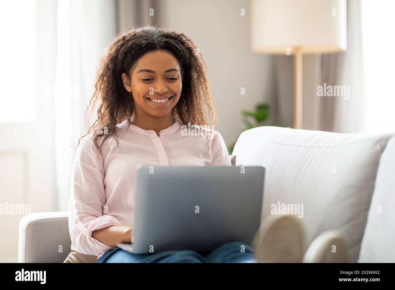 Lady with laptop smiling warmly at home Stock Photo - Alamy