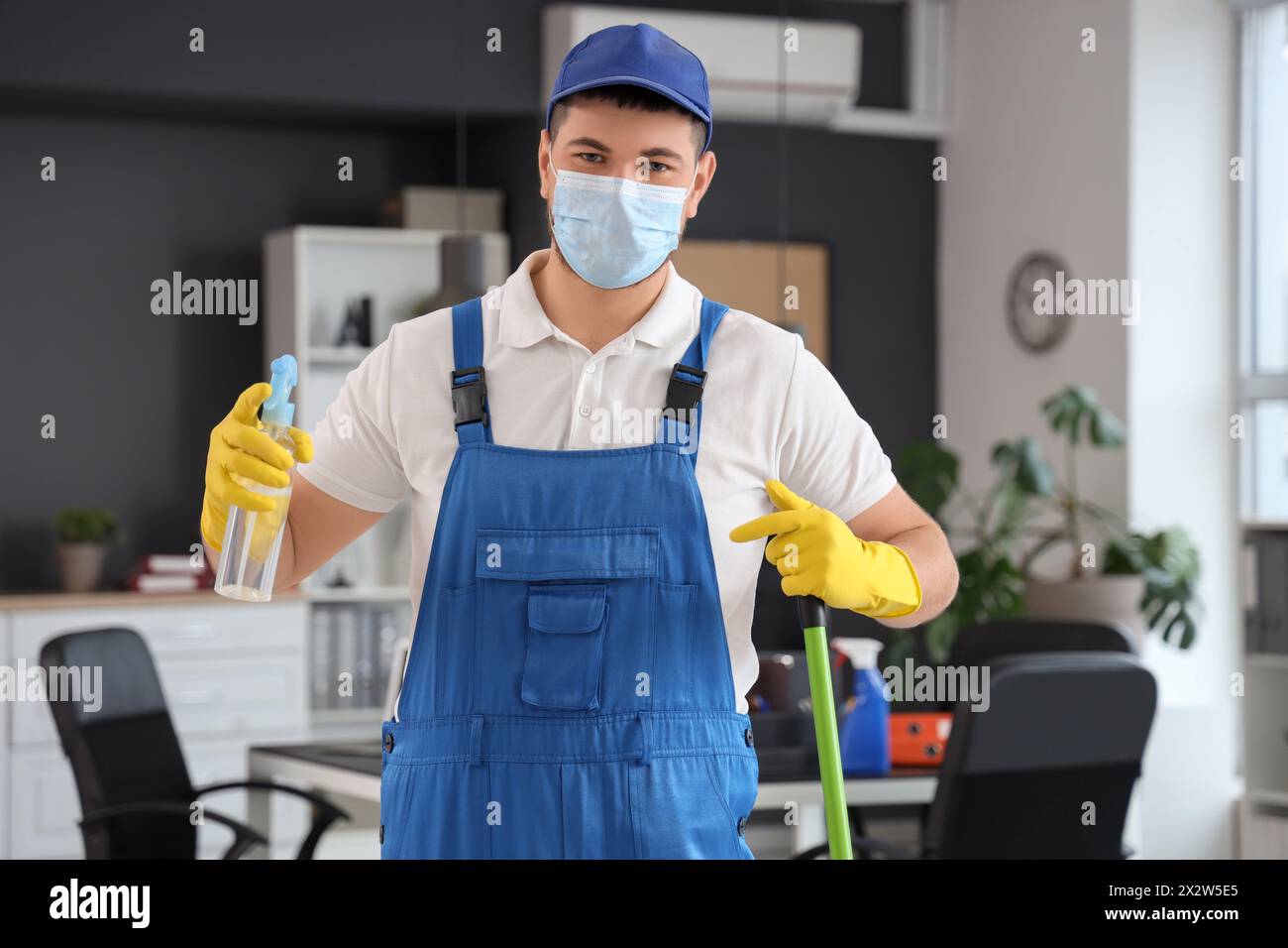 Male worker of cleaning service with mop and detergent in office Stock ...