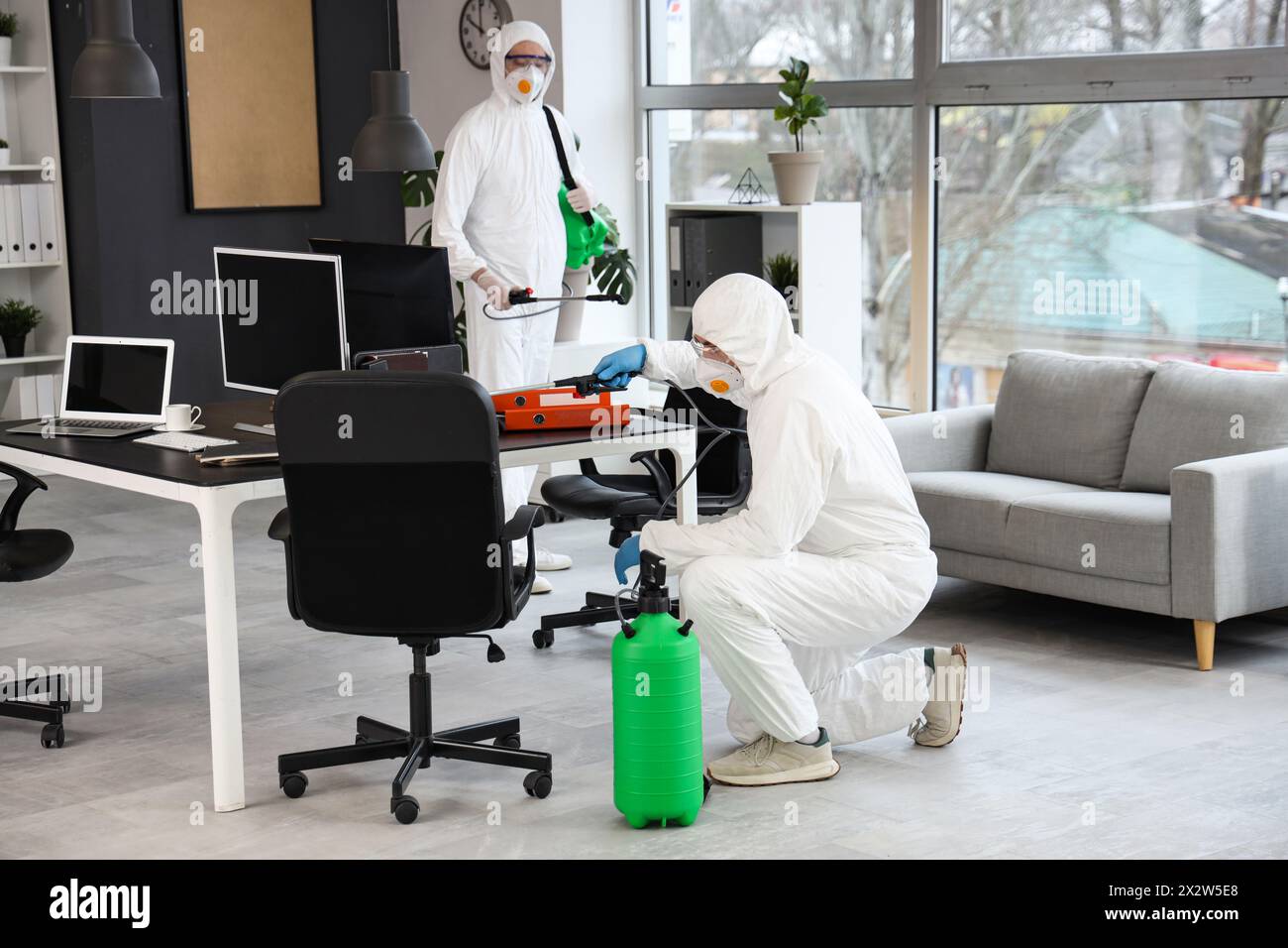 Male workers disinfecting table hi-res stock photography and images - Alamy