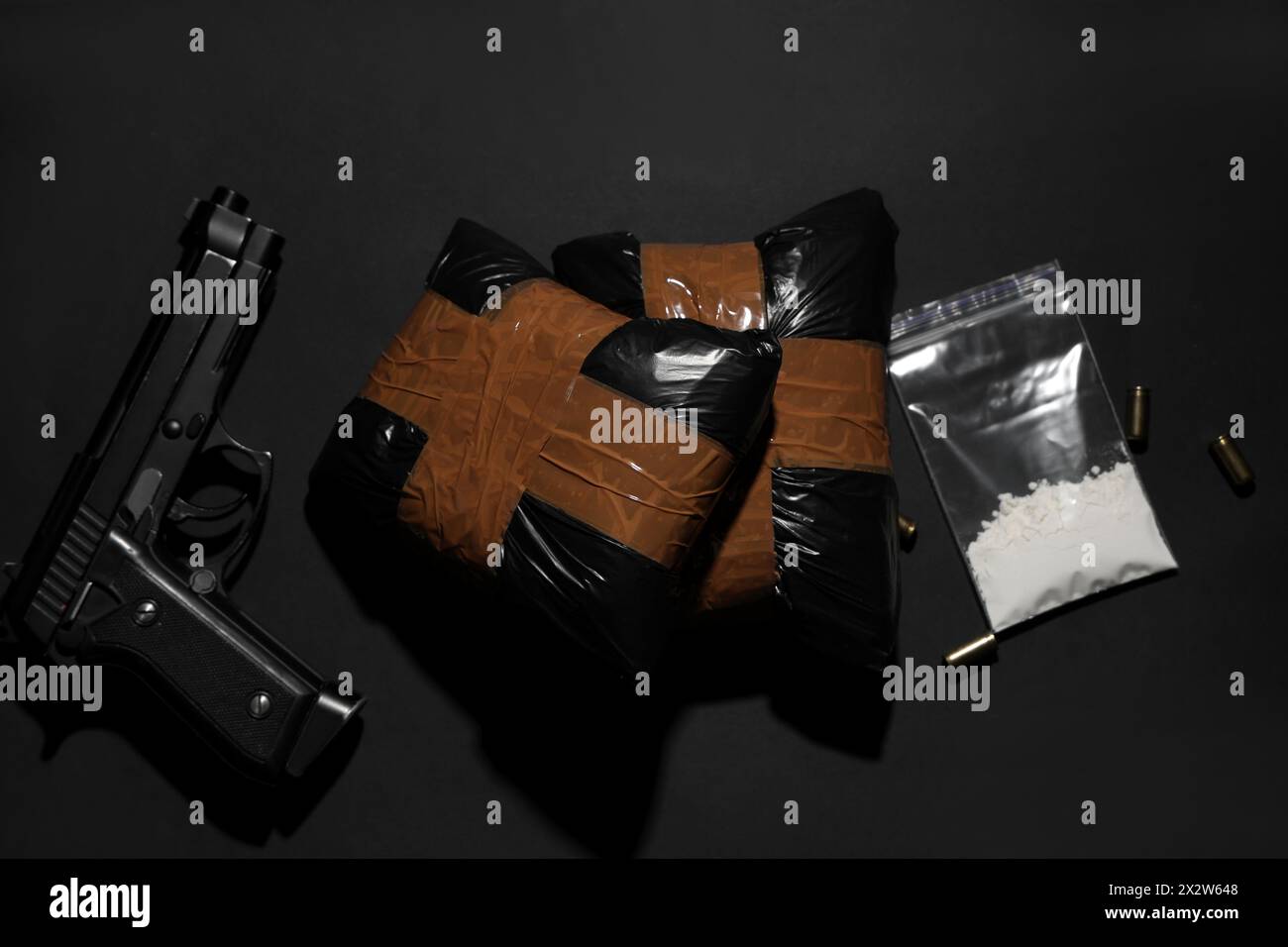 Drug packages with gun and bullets on dark background Stock Photo - Alamy