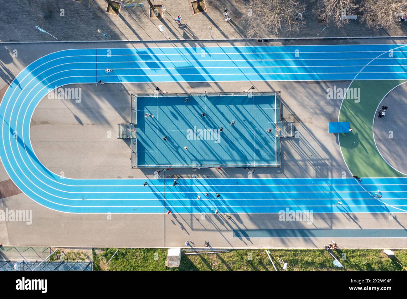 Aerial view of blue running track and multi-sport court in public park ...