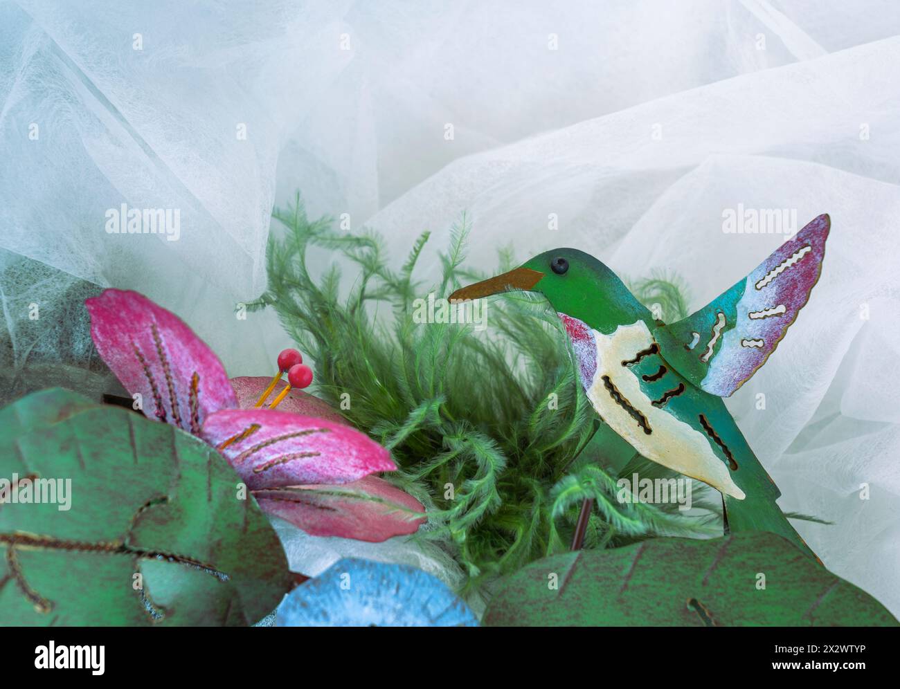 Secret garden of hummingbird shows feathers, cloth & metal flowers ...