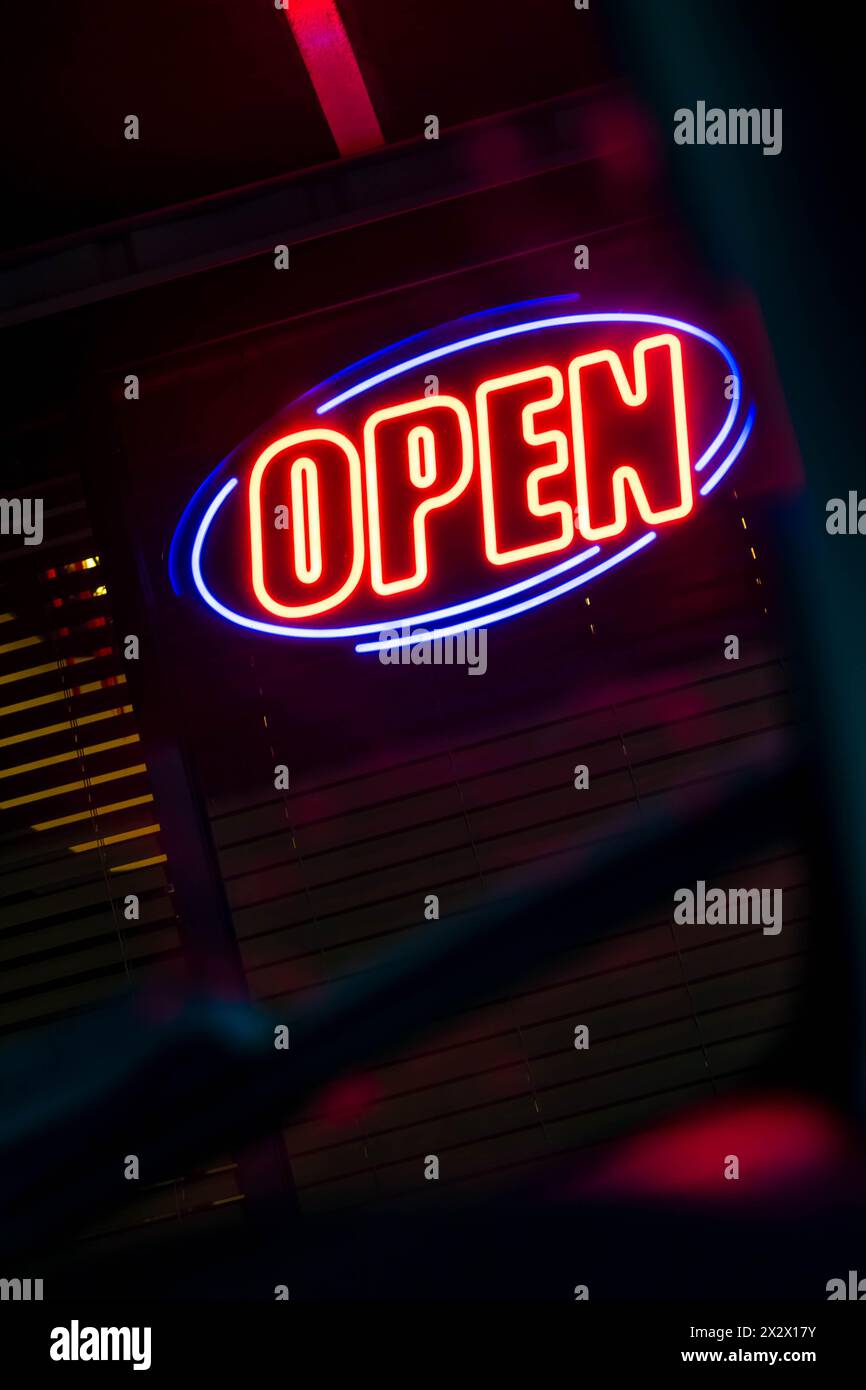 Neon LED open sign on a local business window late at night seen ...