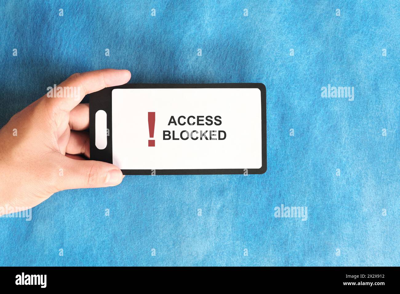 Hand holding a mobile phone with Restricted Site and Website Blocked ...