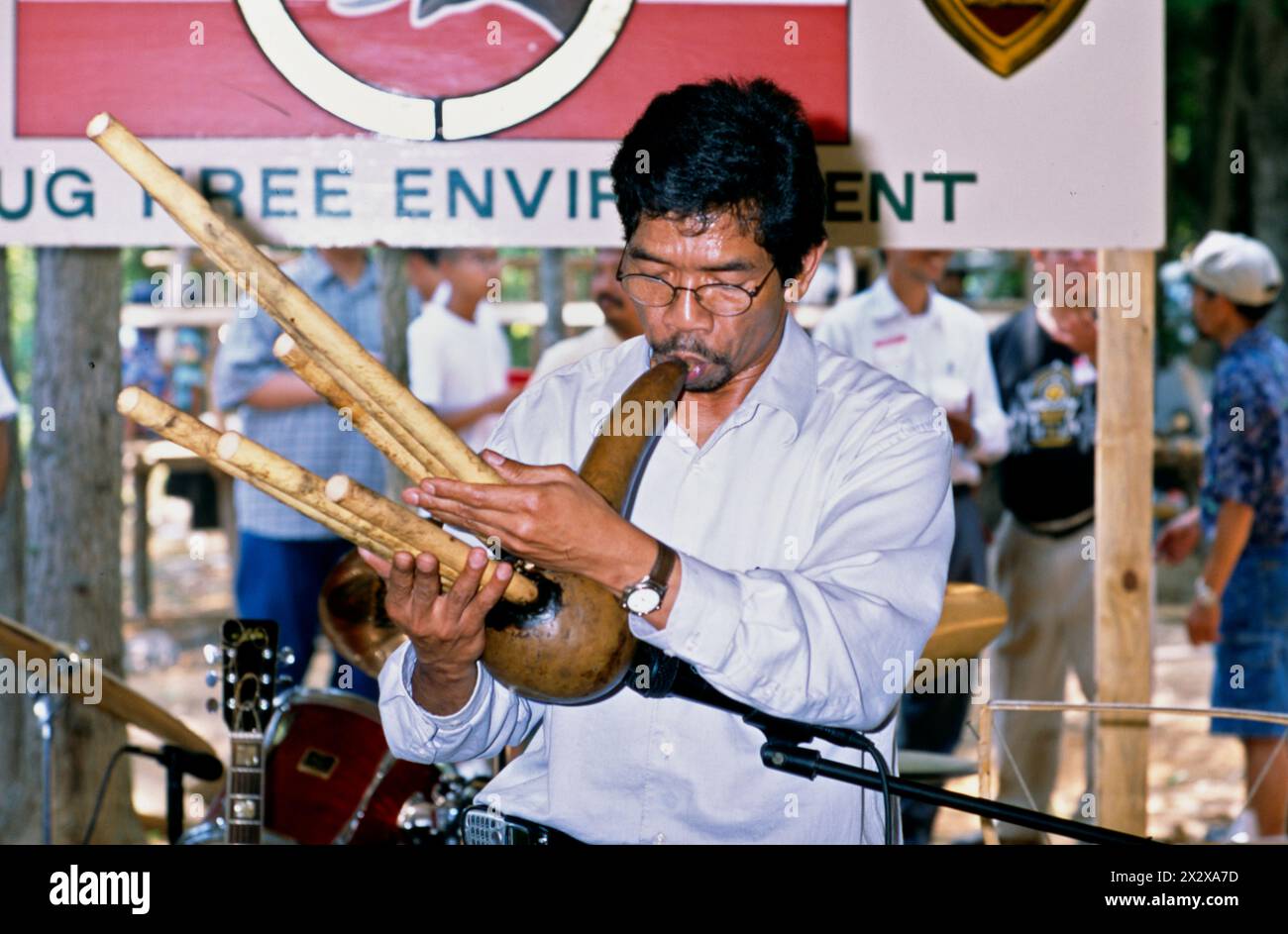 An ethnic Ede man playing a traditional musical instrument at a ...