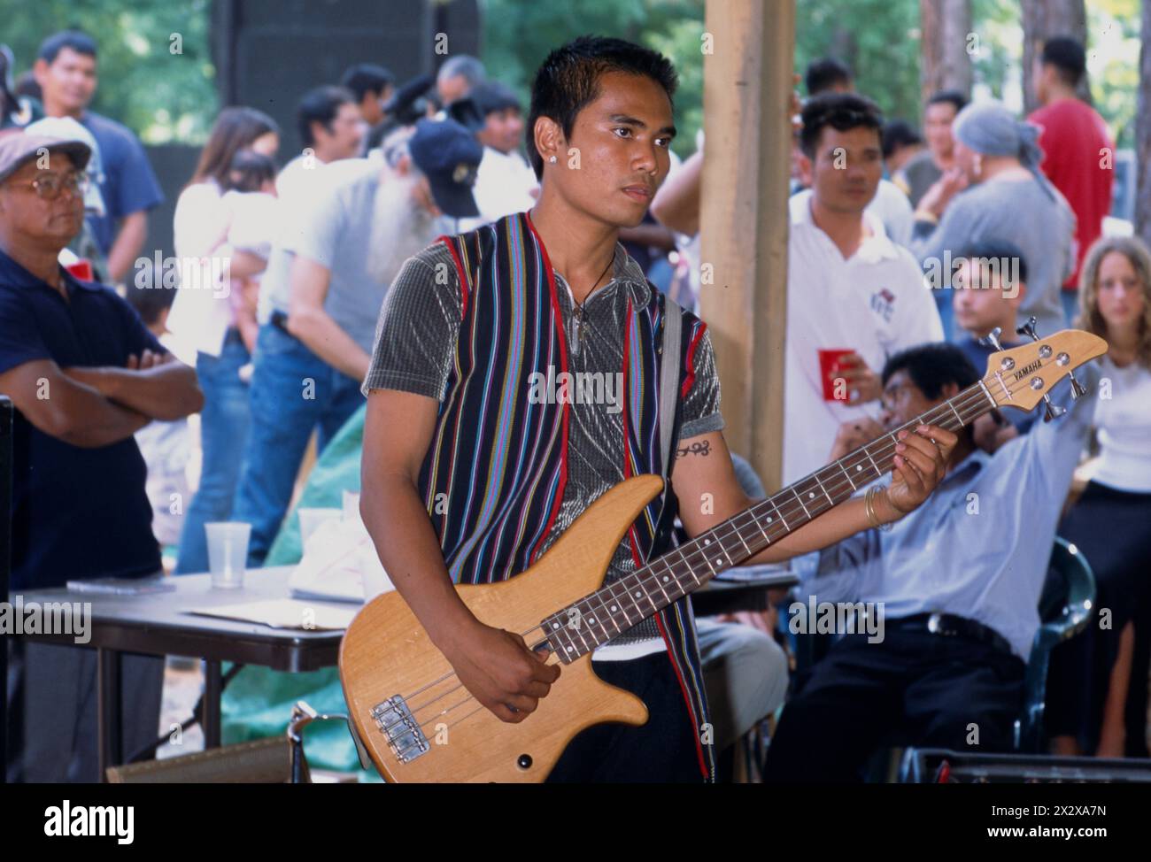 An ethnic Ede man playing bass guitar at a festival of indigenous ...