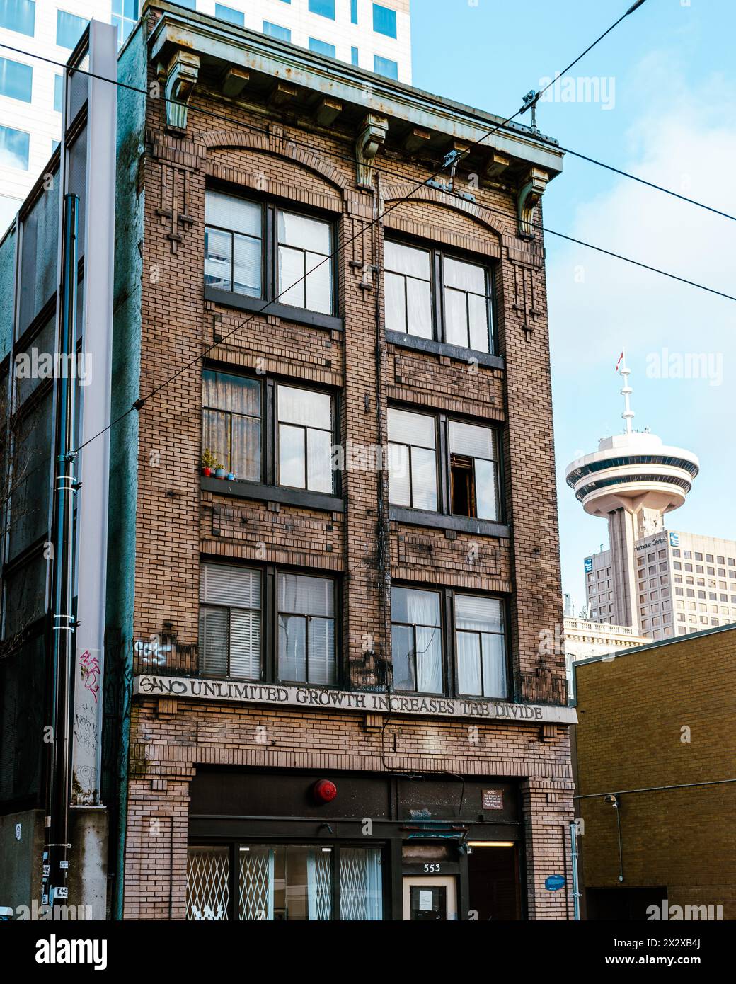 An old heritage brick building, stained by neglect, is adorned by a few ...