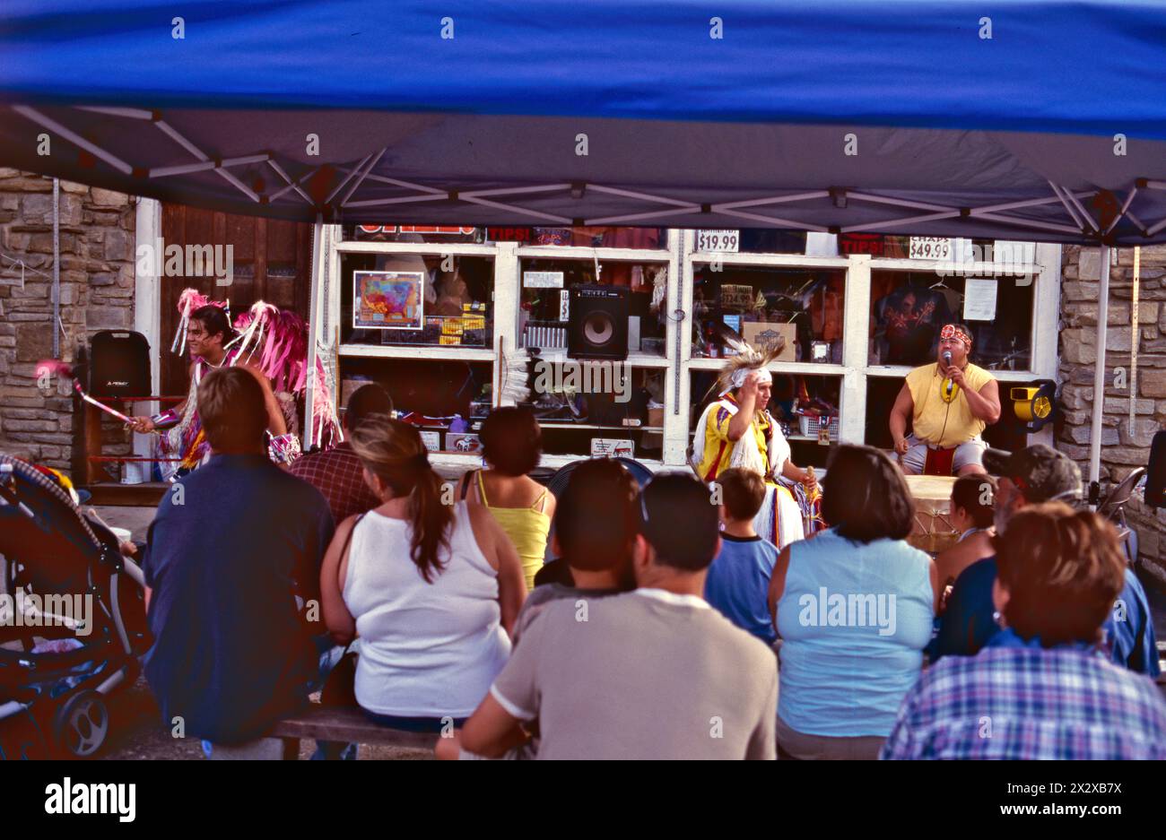 A crowd of tourists is entertained while visiting the Cherokee Indian ...