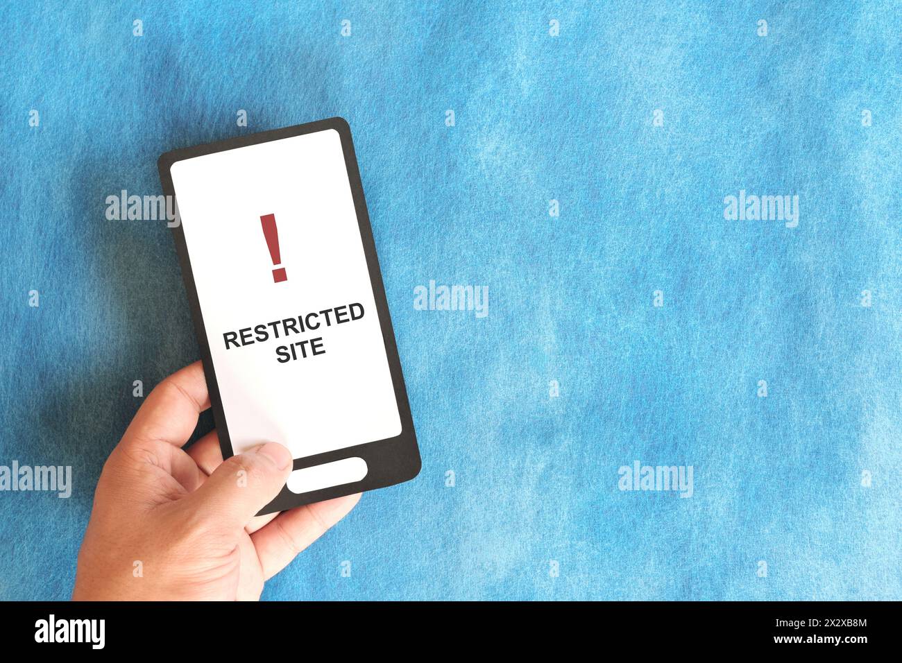 Hand holding a mobile phone with Restricted Site and Website Blocked ...