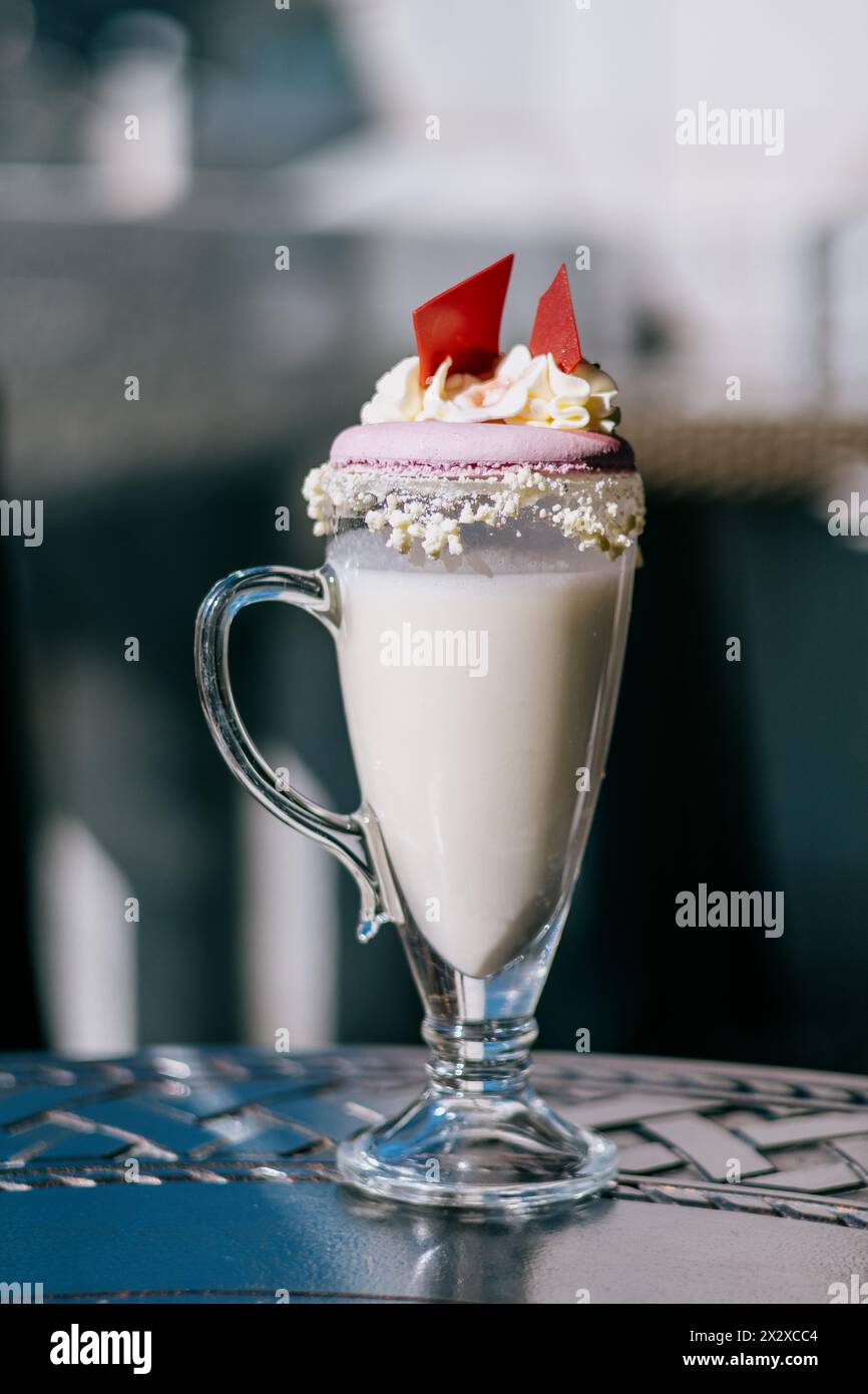 A glass of cherry blossom white cocoa, rimmed with a white chocolate ...