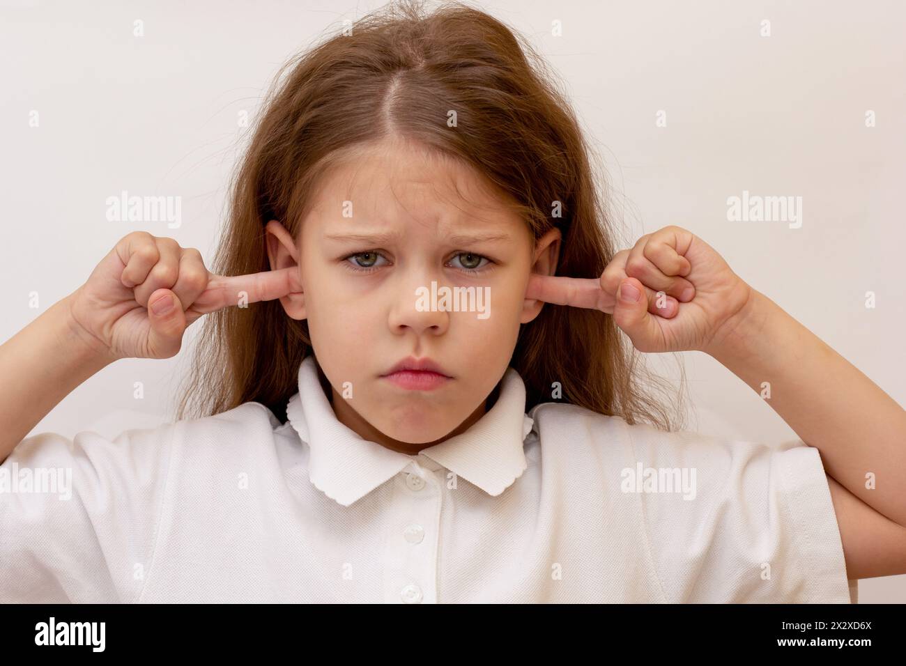 Portrait of caucasian child close ears by fingers on white background ...
