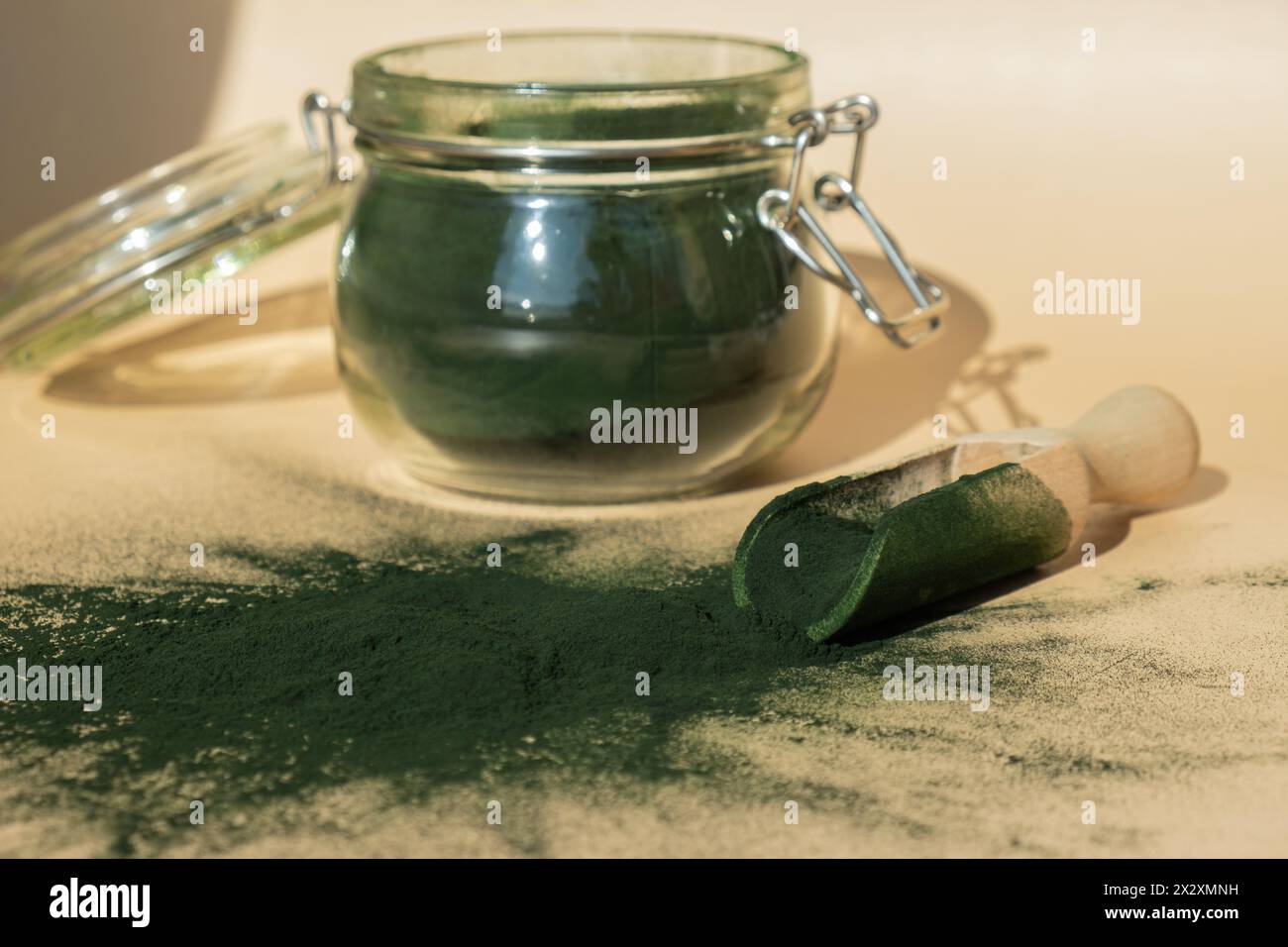 Organic blue-green algae spirulina powder food in glass jar with wooden ...