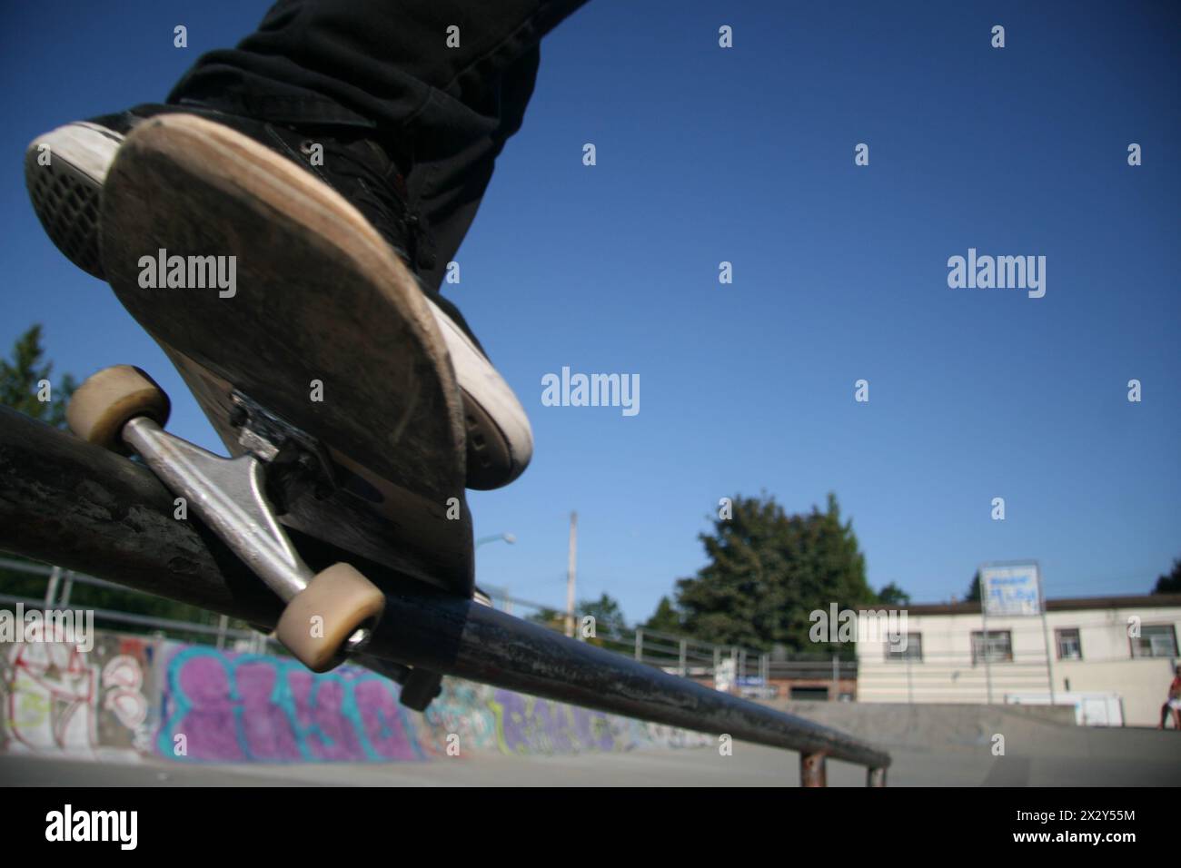 Skateboarder Grinding on Rail as seen from below Stock Photo - Alamy
