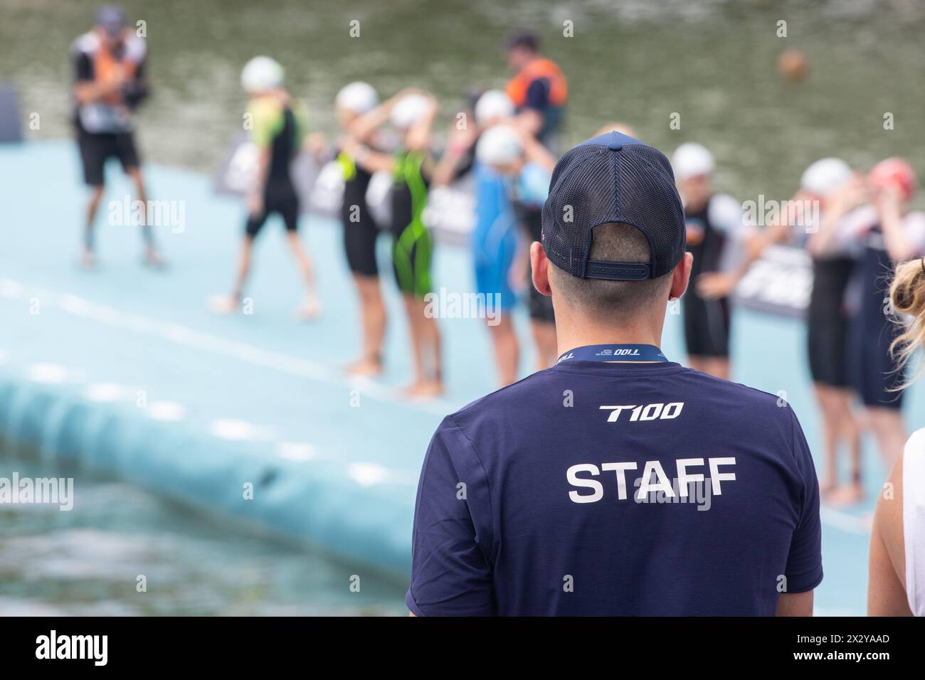 13 April 2024. Back view of a T100 working staff looks at the triathlon ...