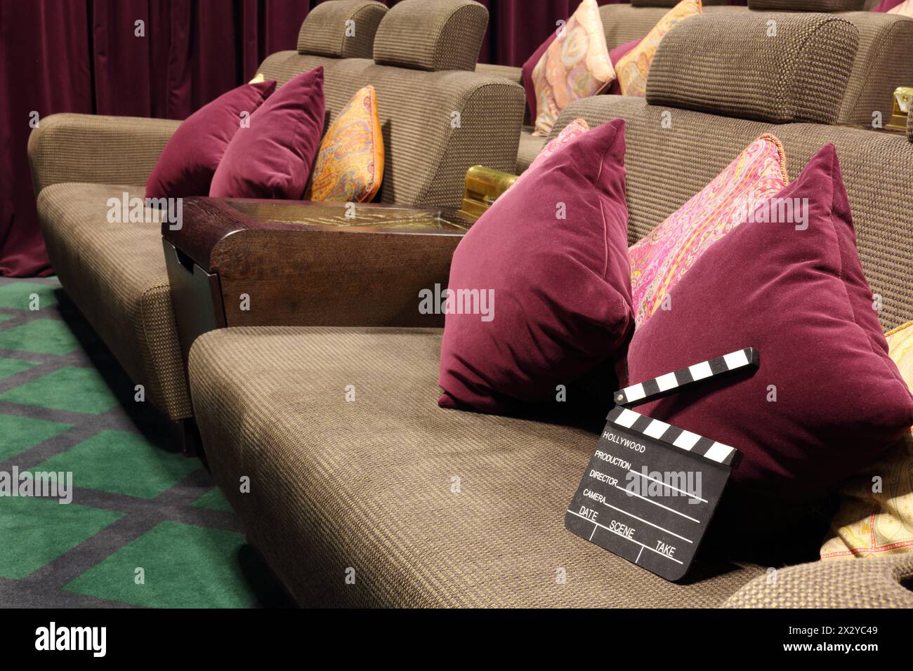 Movie clapper board on soft sofa with cushions in cinema theatre Stock ...