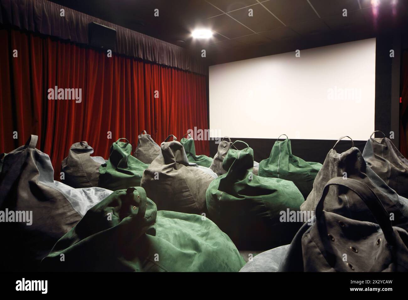 Back of comfortable seats like sacks and screen in small movie theater ...