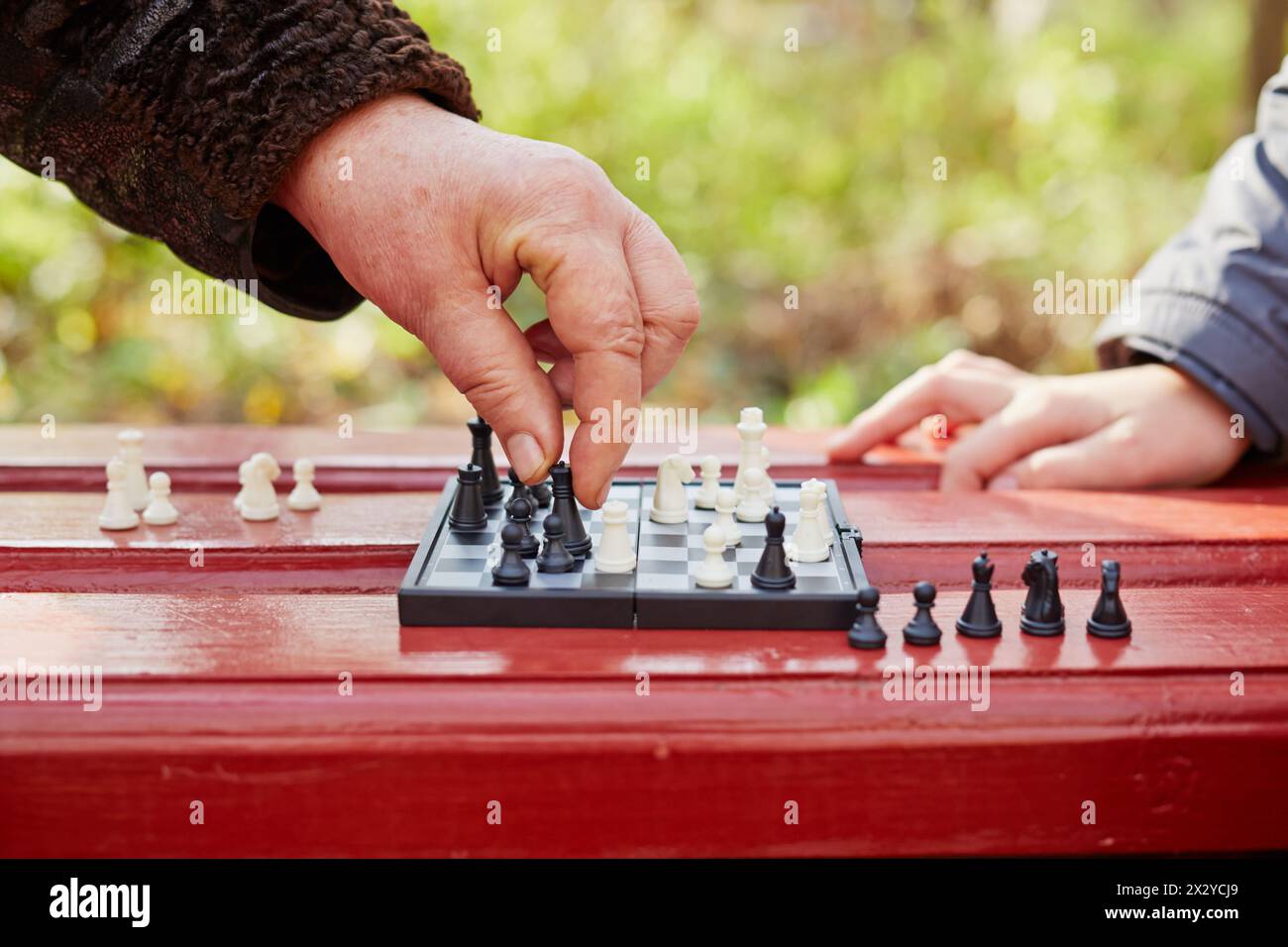Grandmother hand makes move on chessboard in game in park outdoors ...