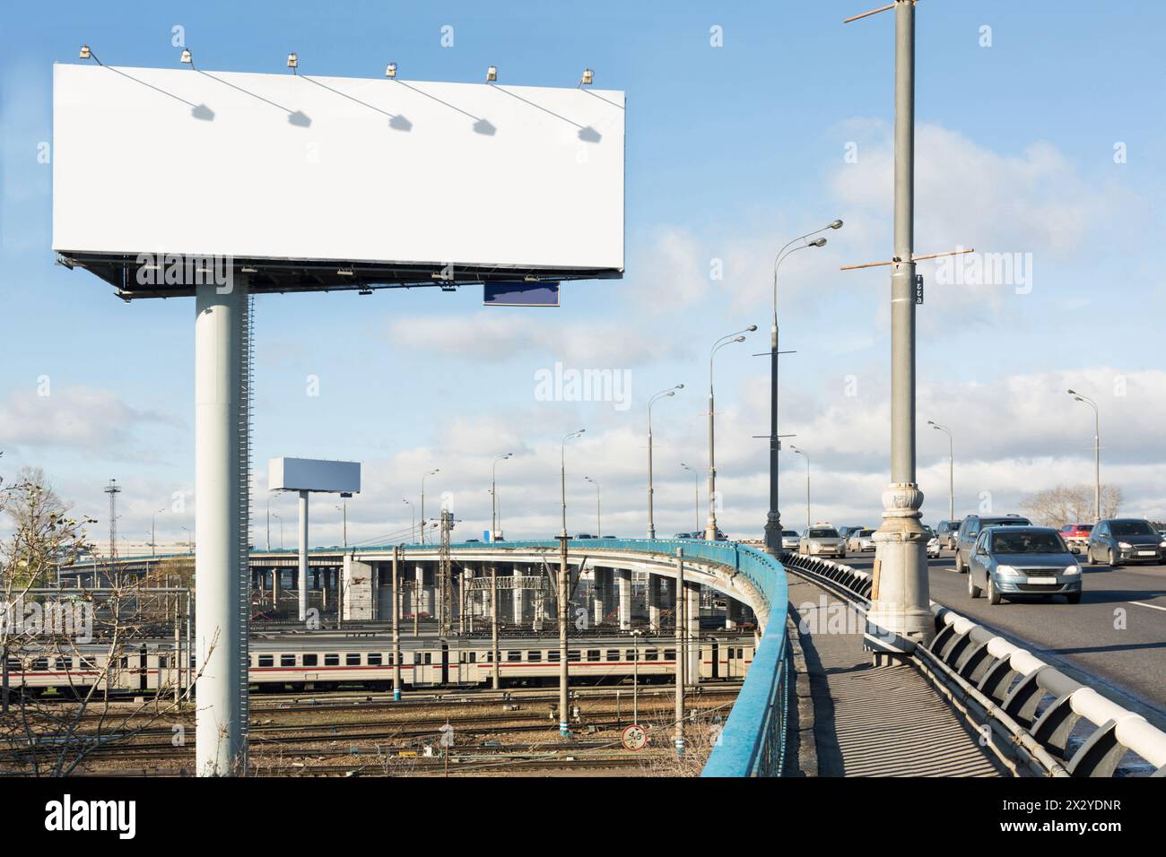 Cars driving on the bridge over the railway past a billboard Stock ...