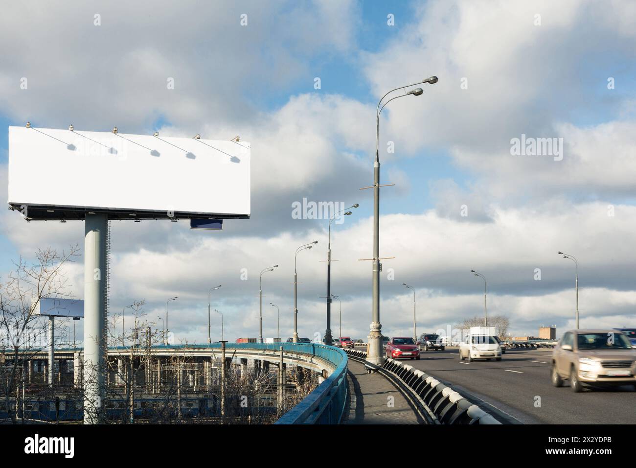 Cars driving on the bridge over the railway past a billboard Stock ...