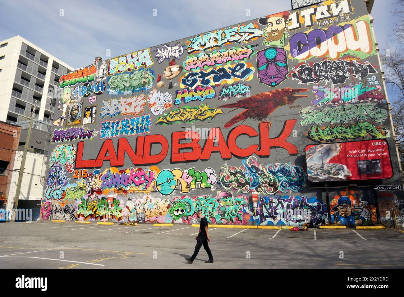 Person walking past colorful urban graffiti and murals painted on the ...