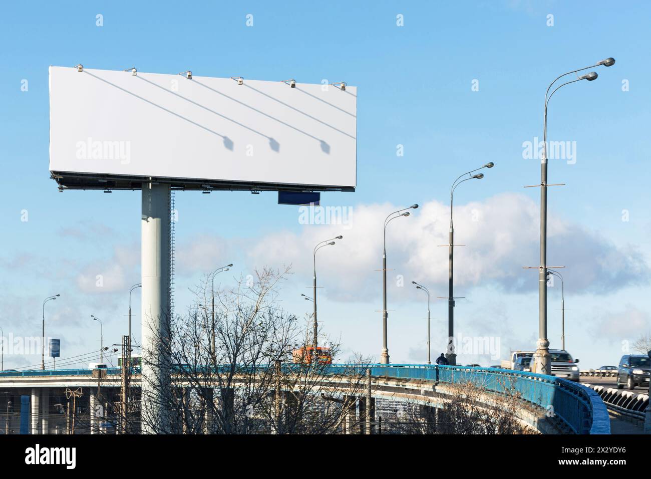 Cars driving on the bridge over the railway past a billboard Stock ...