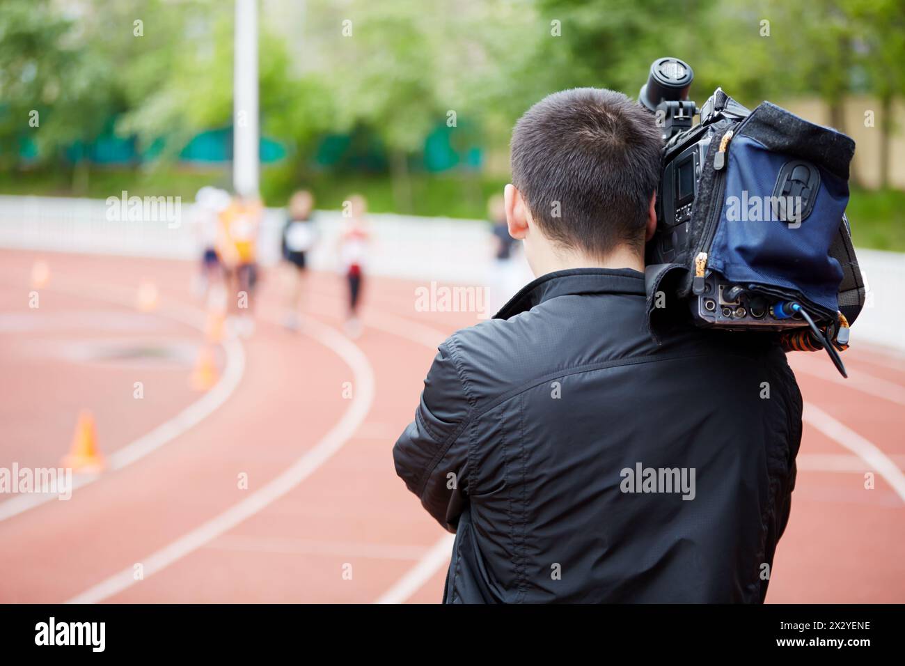 Cameraman shoots running races, view from back Stock Photo - Alamy
