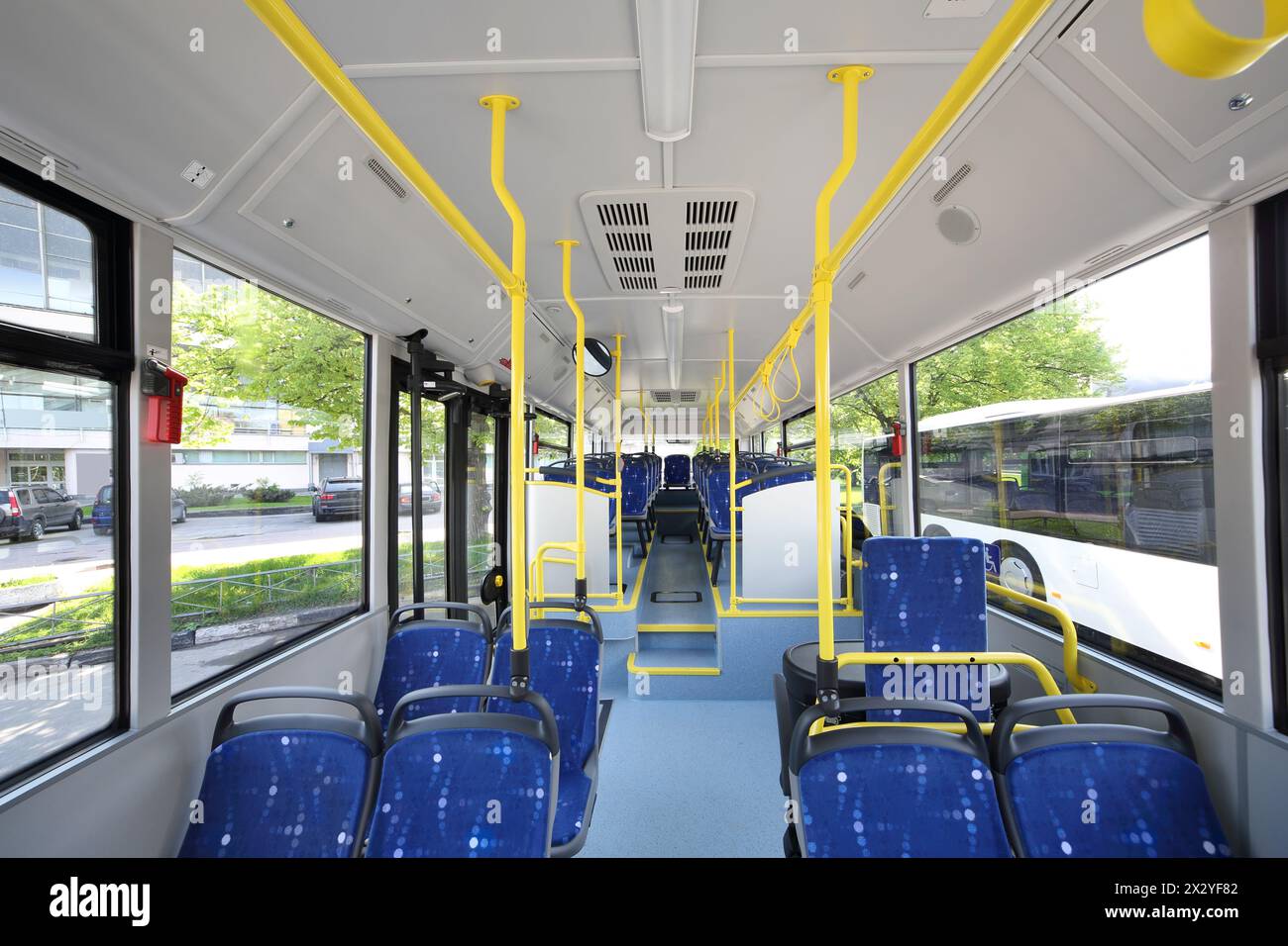 Blue seats inside saloon of empty city bus with big transparent windows ...
