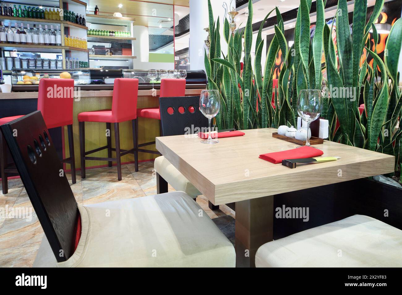 Square table with glasses and bar in hall of cozy Japanese restaurant ...