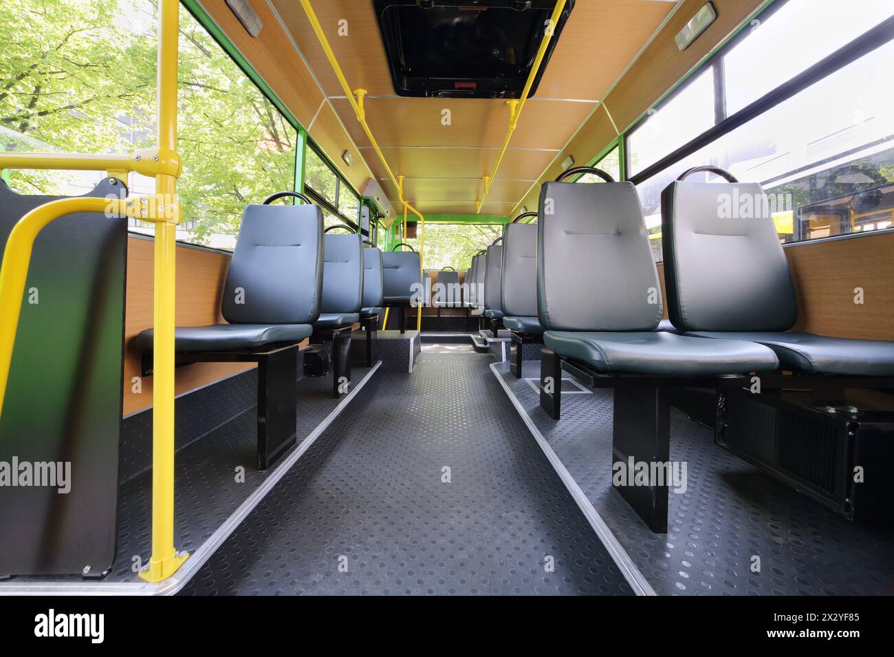 Rows of grey seats inside clear saloon of empty city bus with skylight ...