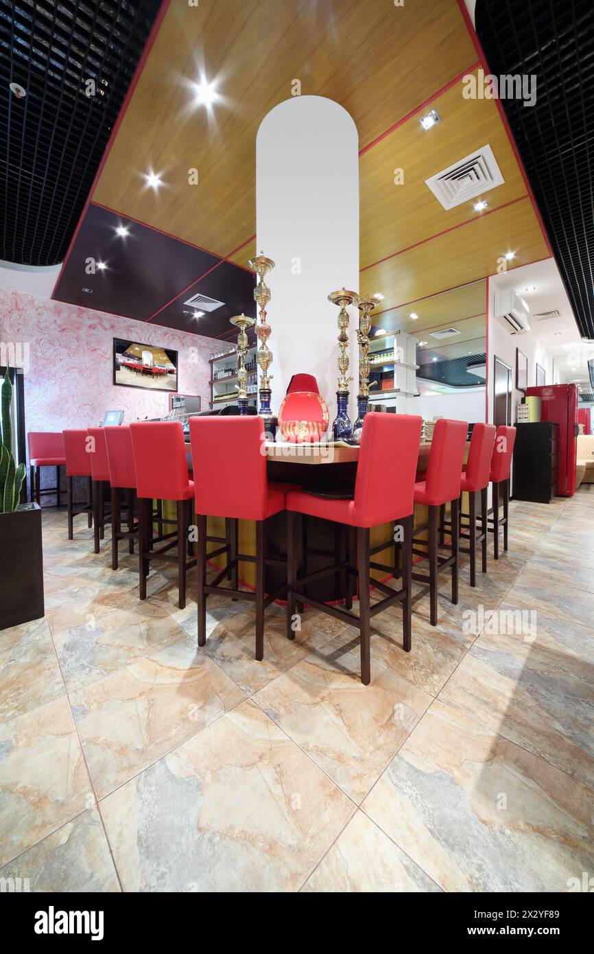 Bar counter with tall red chairs in hall of cozy Japanese restaurant ...