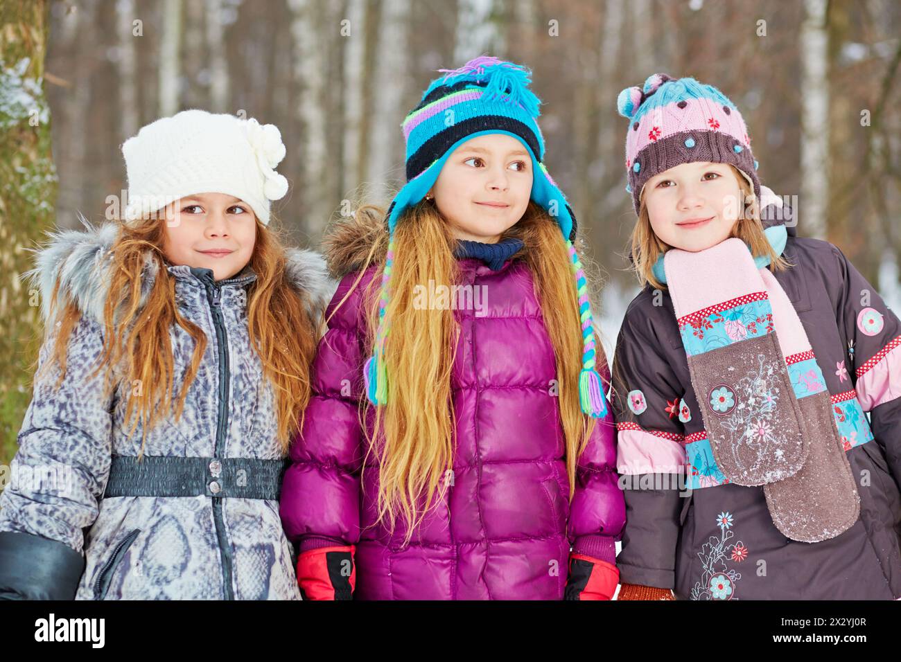 Three girls-friends stand in winter park Stock Photo - Alamy