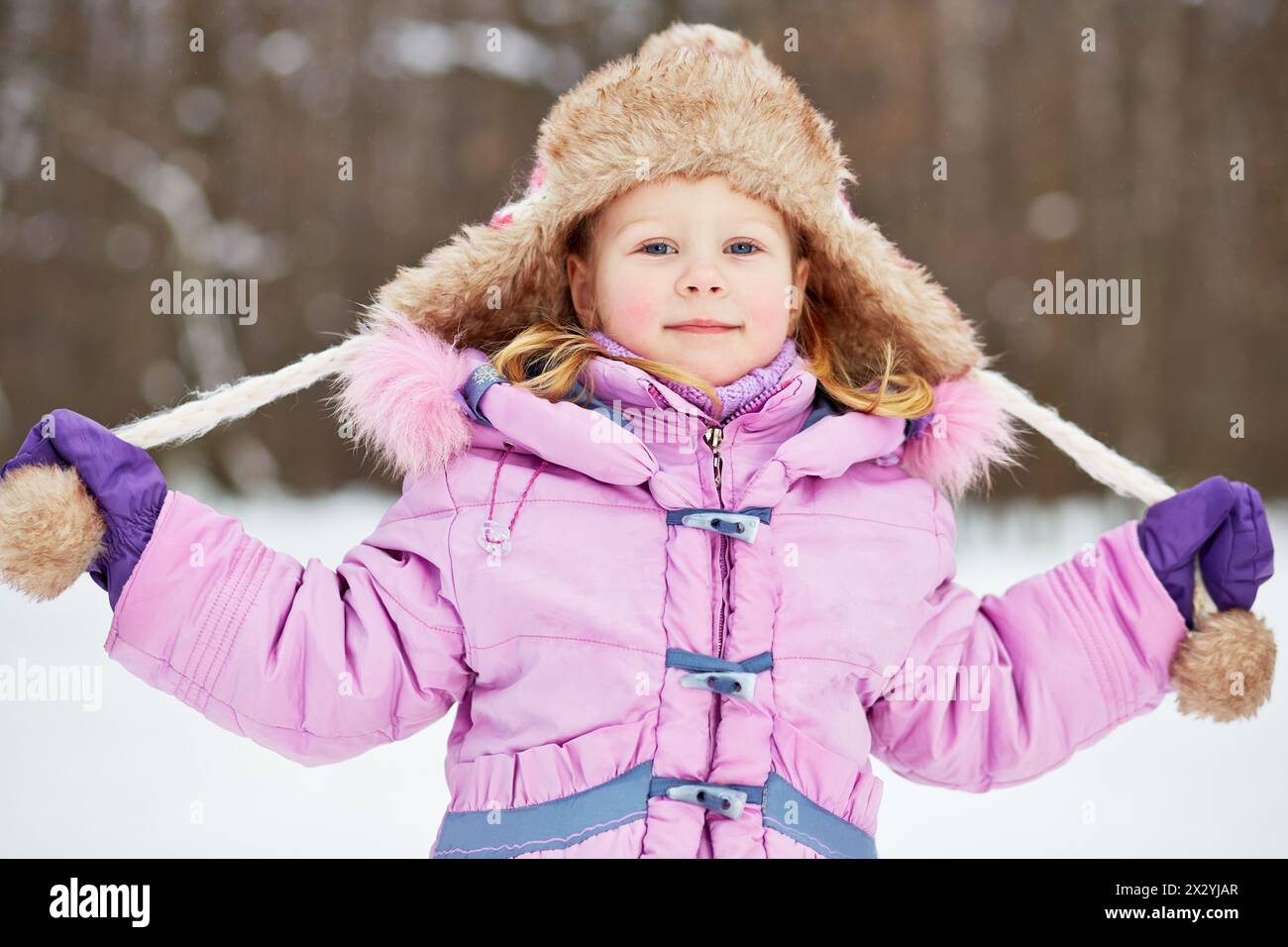 Half-length portrait of smiling little girl in pinky jacket with fur ...