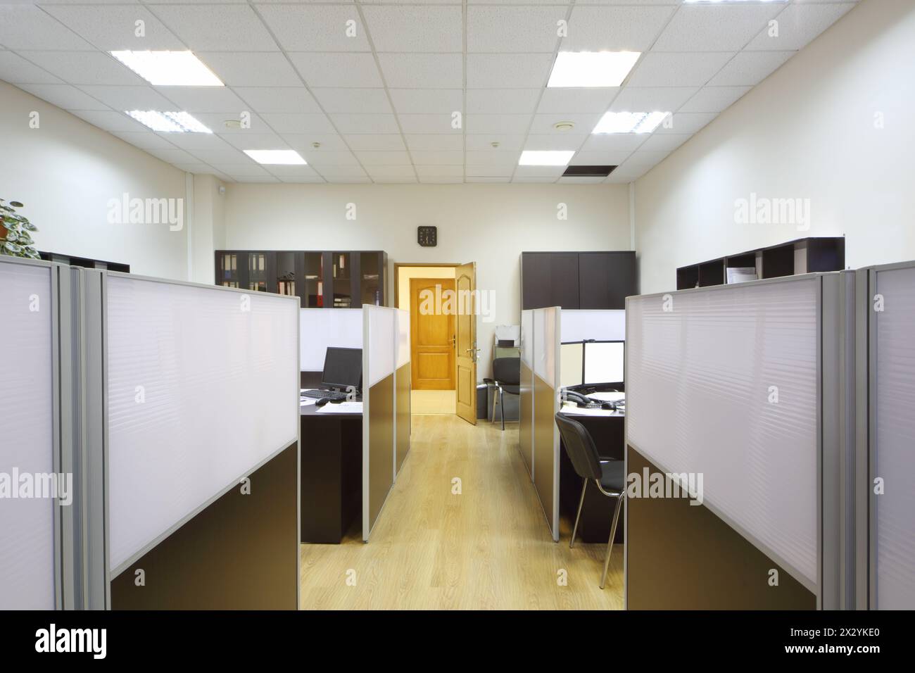 Empty working areas with desktops and documents separated by partitions ...