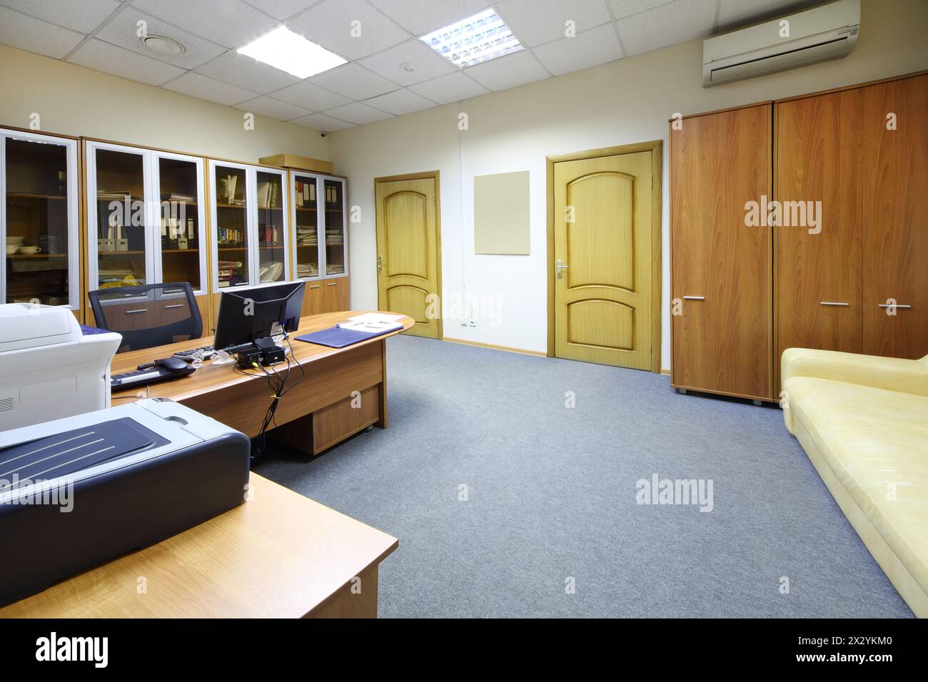 Empty working area with desktop, bookcase and sofa in modern office ...