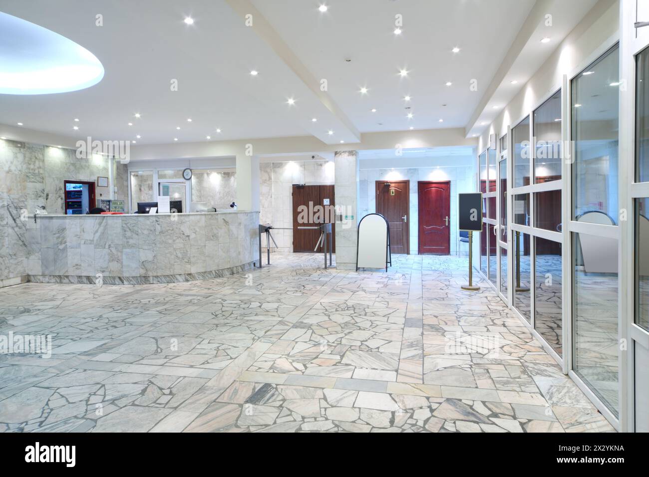Reception area, glass entrance doors in office building at evening ...